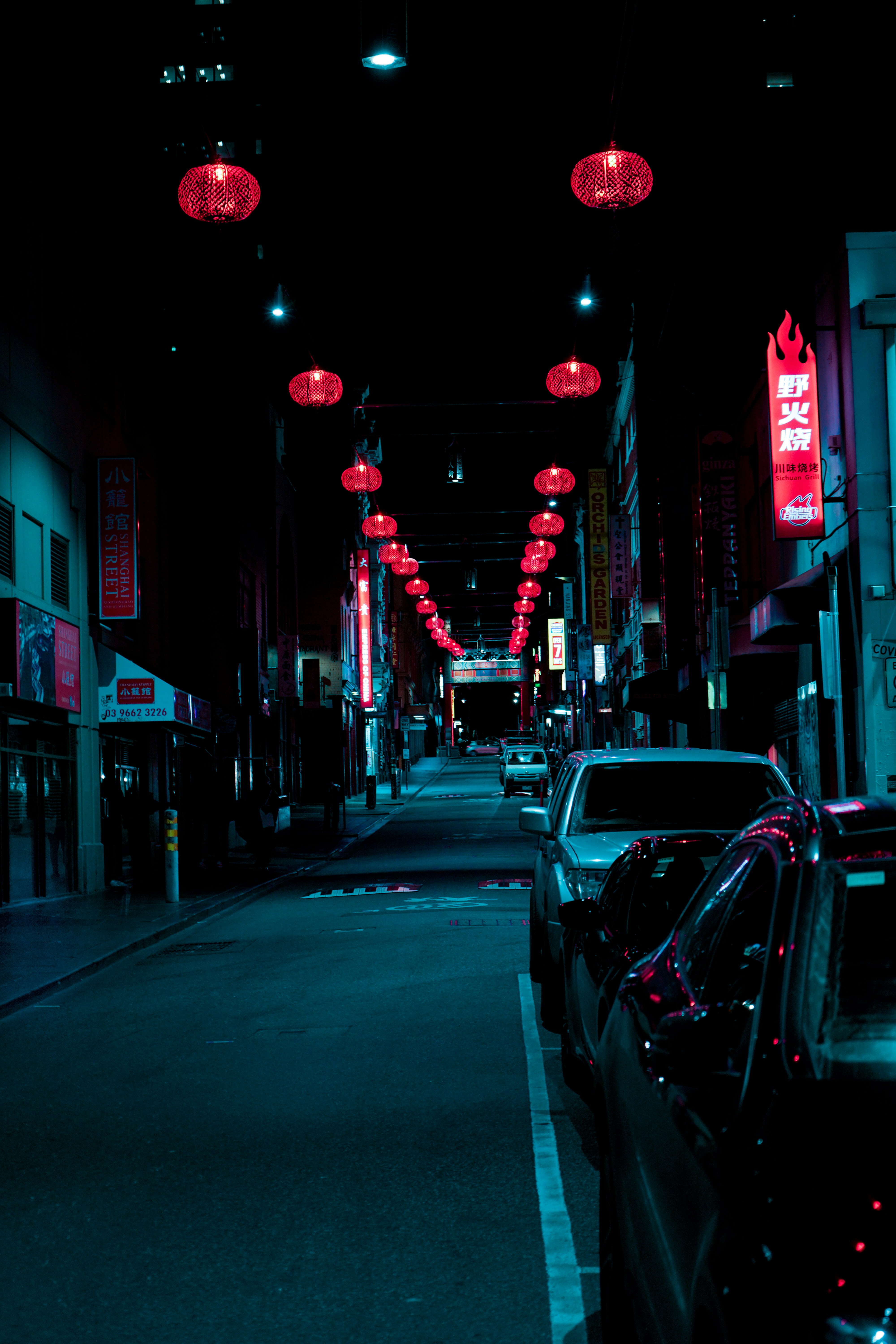 A vibrant urban street adorned with glowing red lanterns and neon signs, capturing the essence of nightlife in the city.