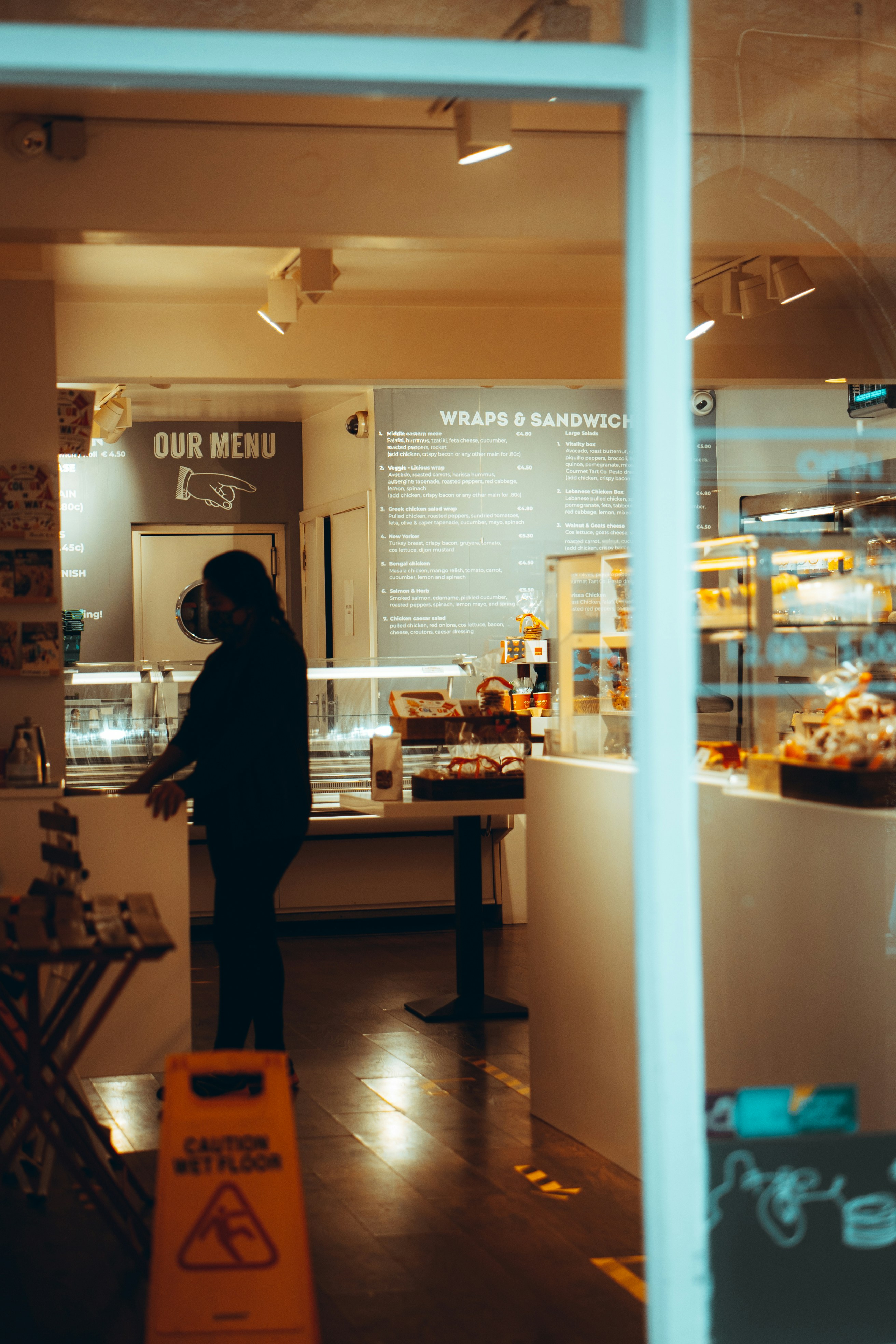 woman in black long sleeve shirt standing in front of food counter