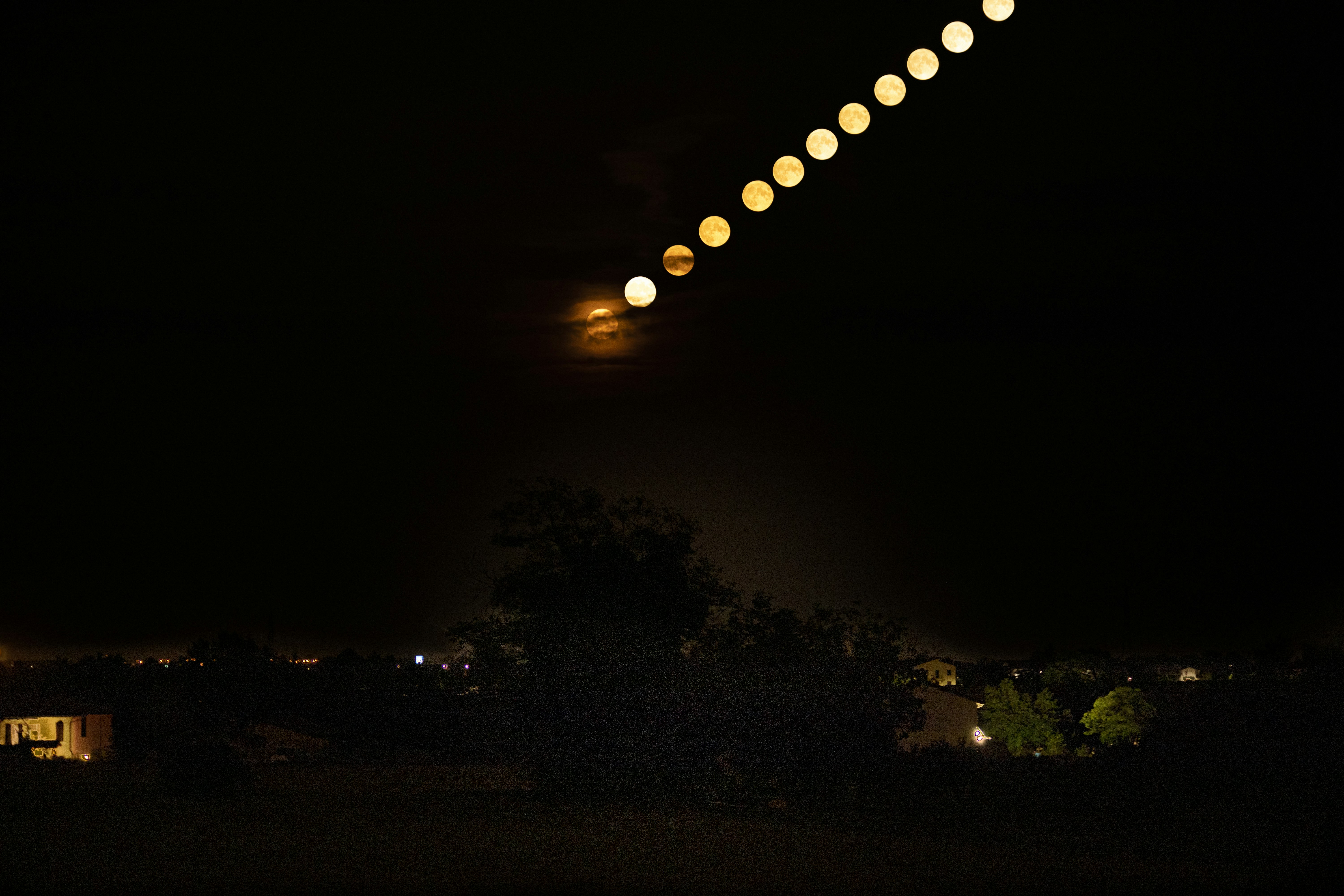 Moonlit Orbs: A Nighttime Arc of Lights Over a Quiet Town