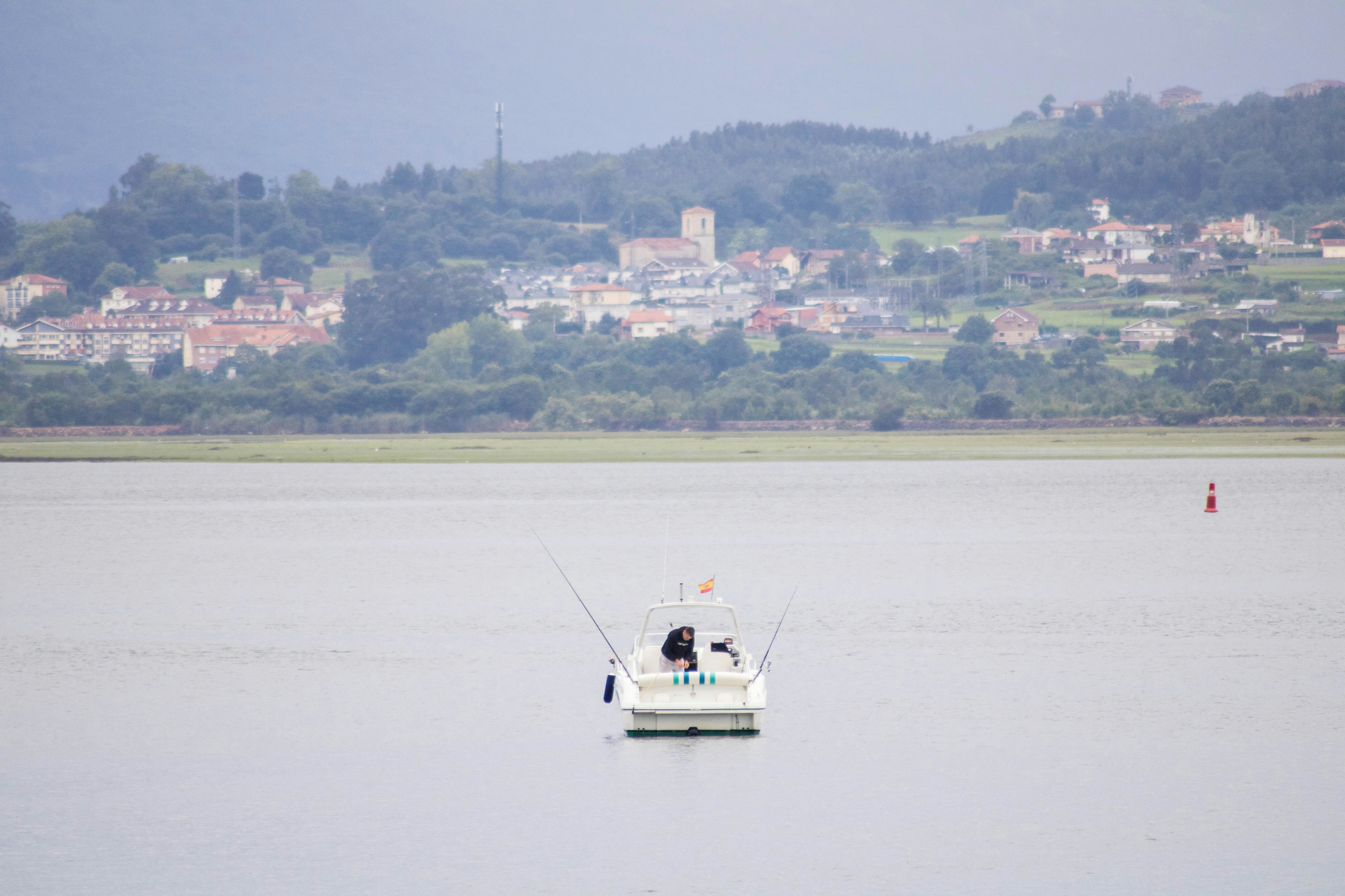 white and blue boat on water during daytime