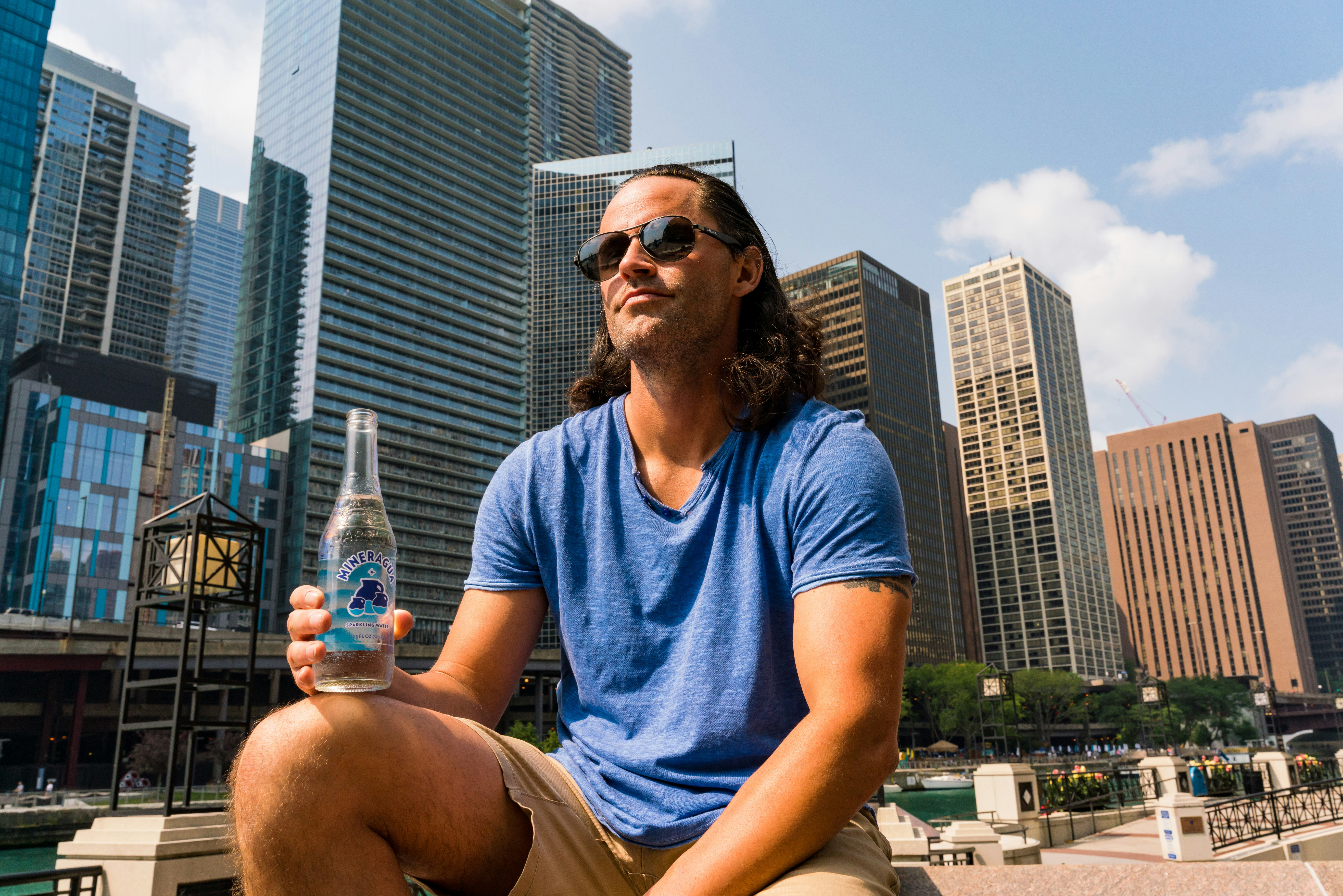 City Portrait on the Riverwalk: A Relaxed Moment with a Soda-Blue T‑shirt
