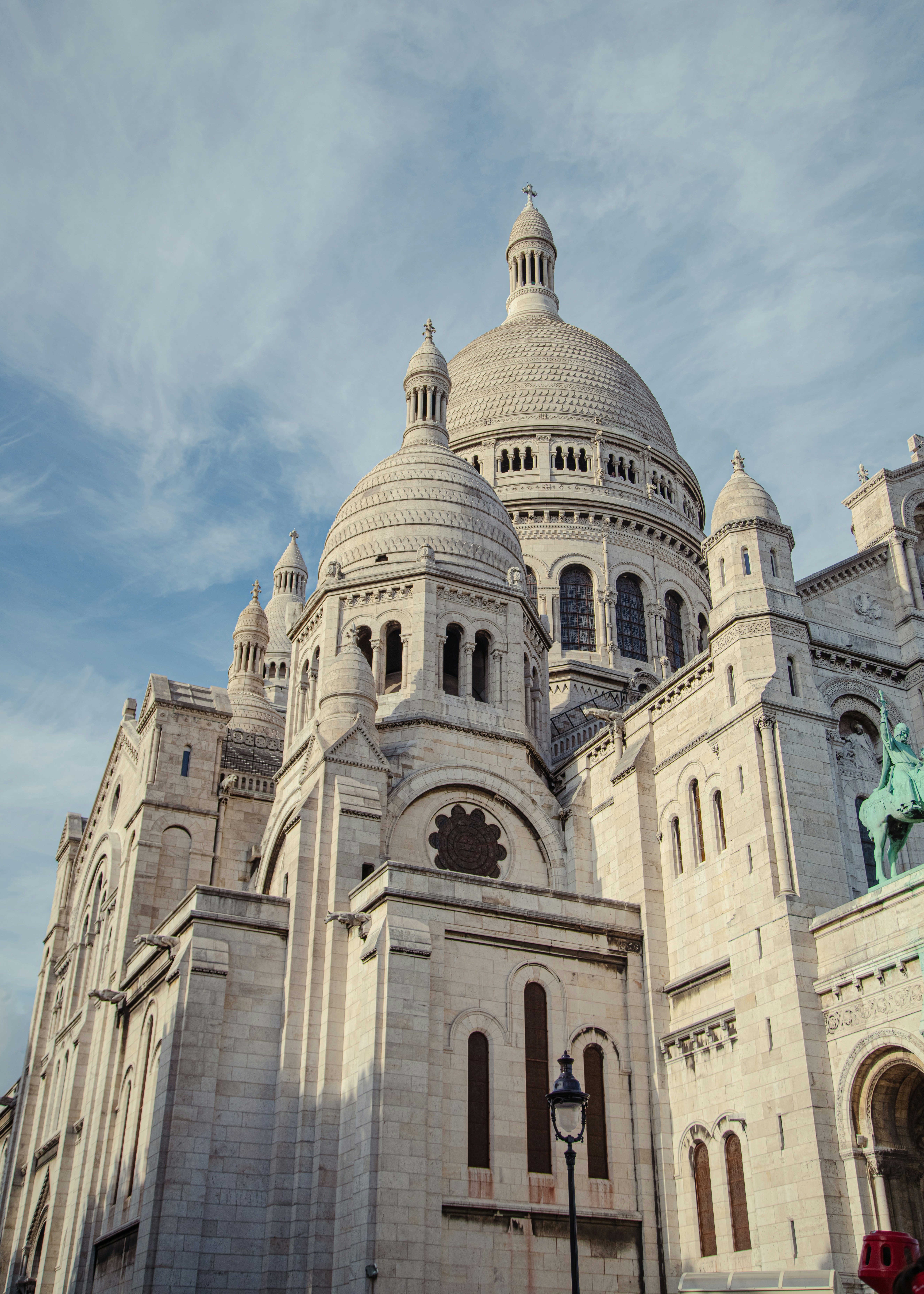 Intricate domes and ornate facades of the Sacré-Cœur Basilica rise against a serene sky, showcasing its architectural beauty.