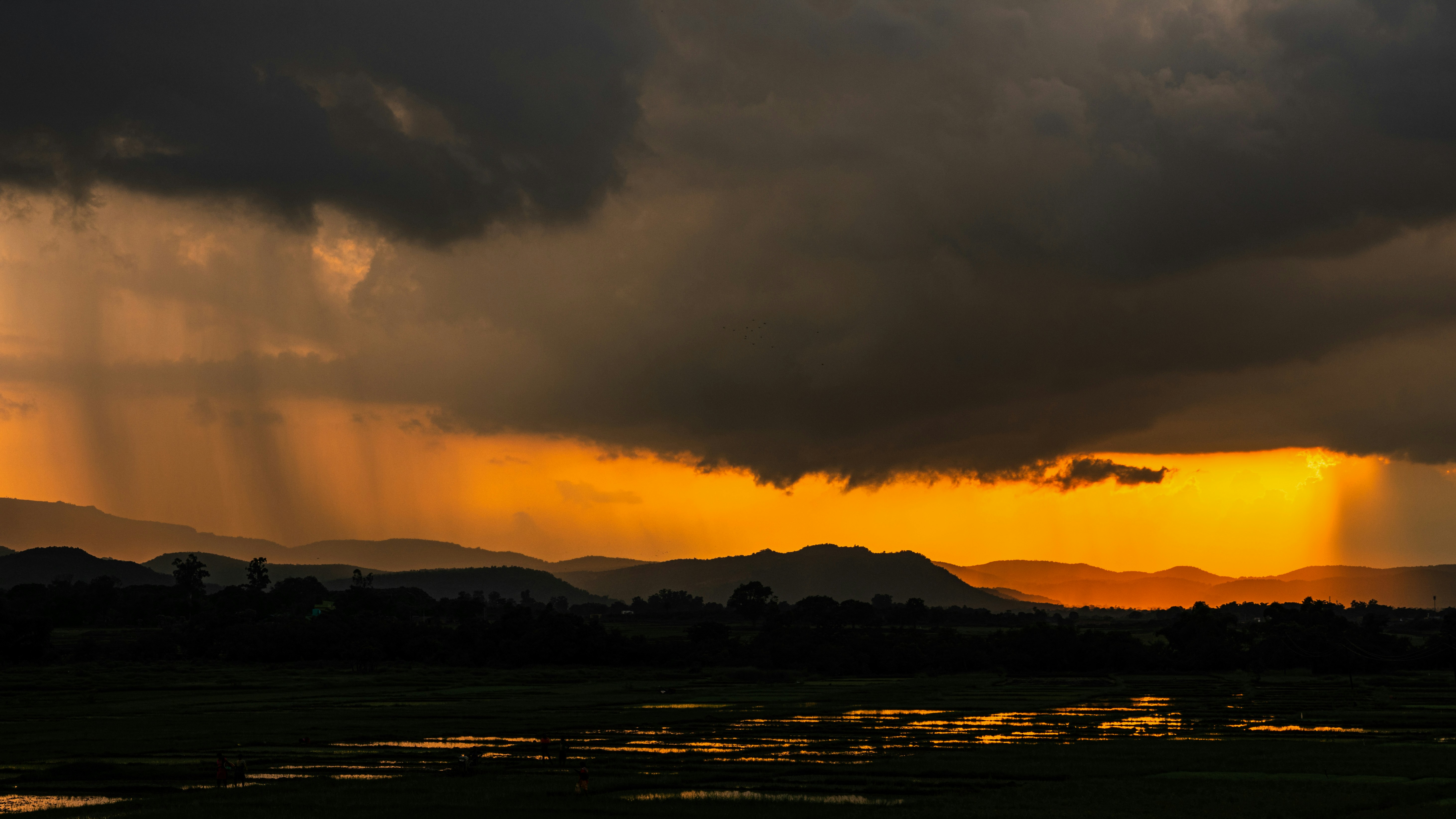 Dusk Sunbeams Cut Through Storm Clouds Over a Quiet Prairie Wetland