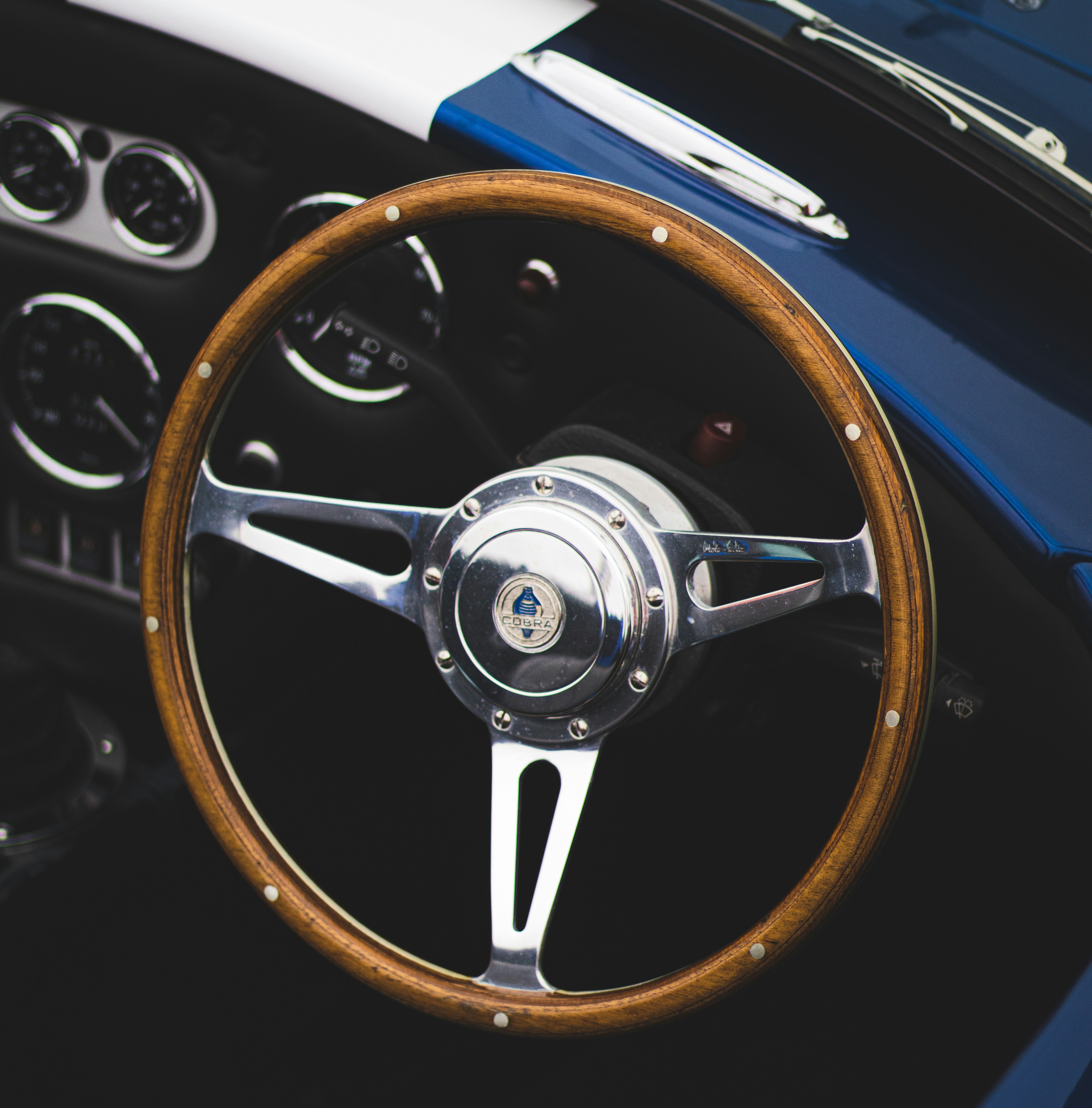 Vintage wooden steering wheel centerpiece in classic blue cockpit