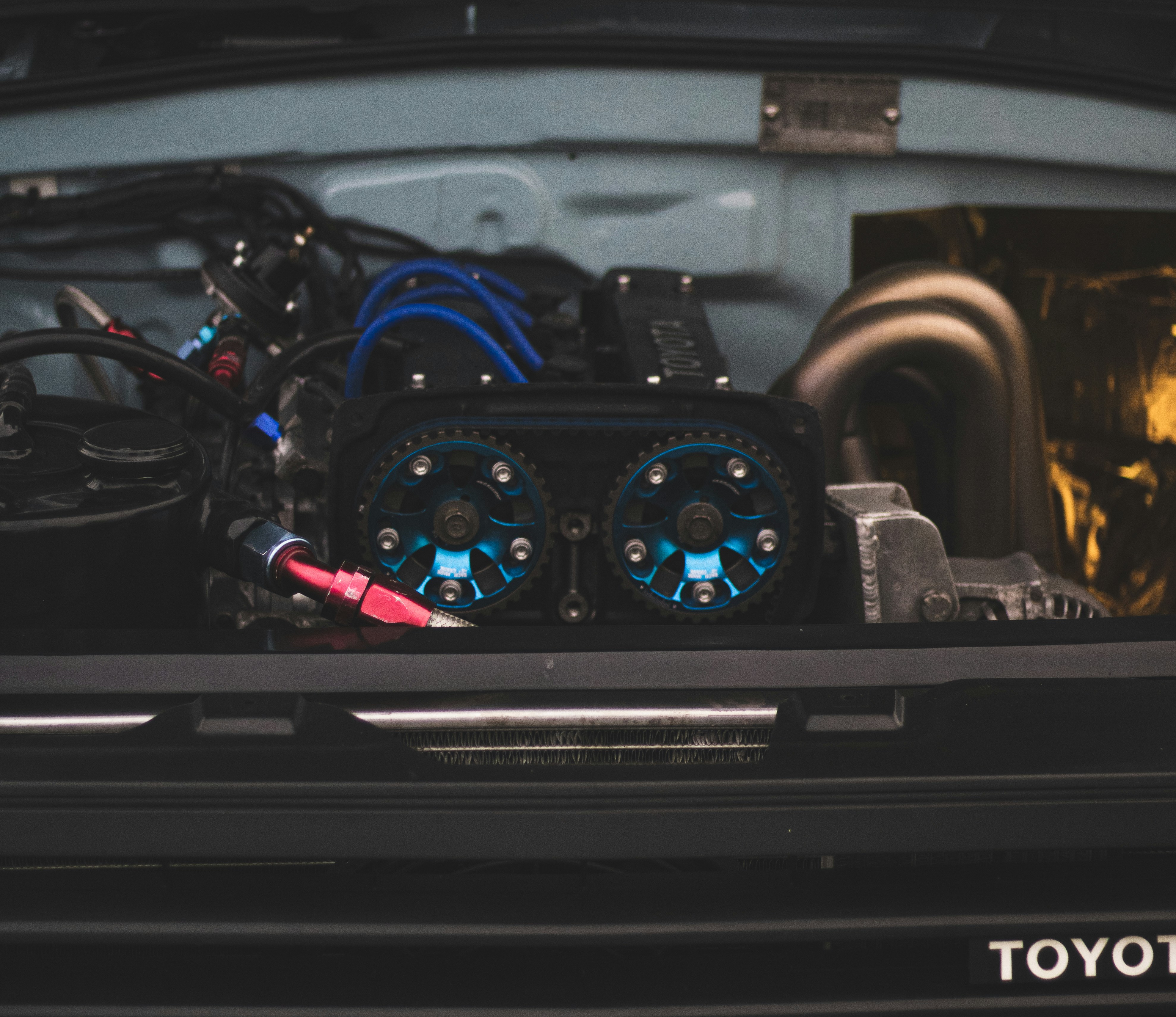 Twin blue coil packs beneath the hood of a Toyota trunk setup