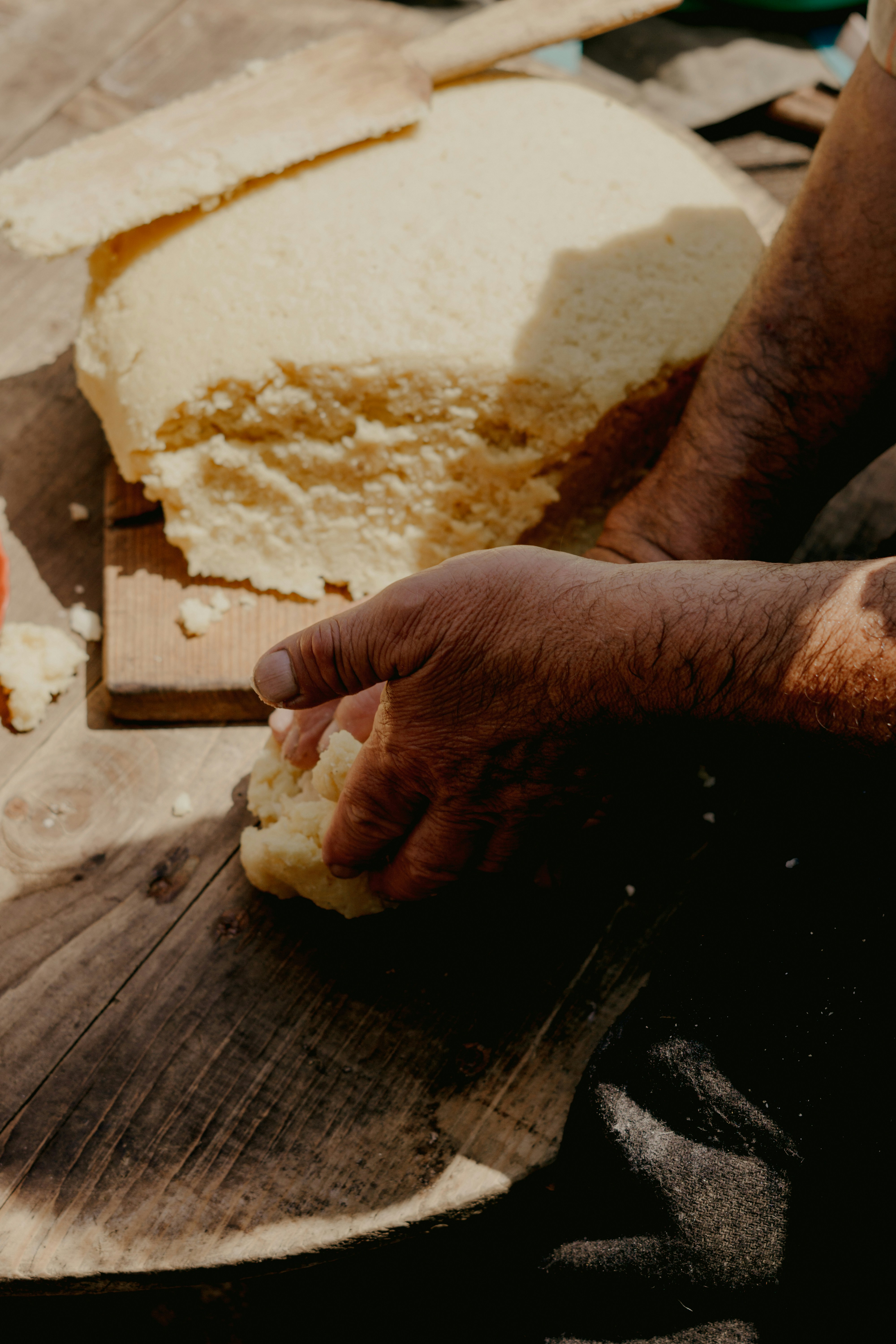 person holding brown wooden rolling pin