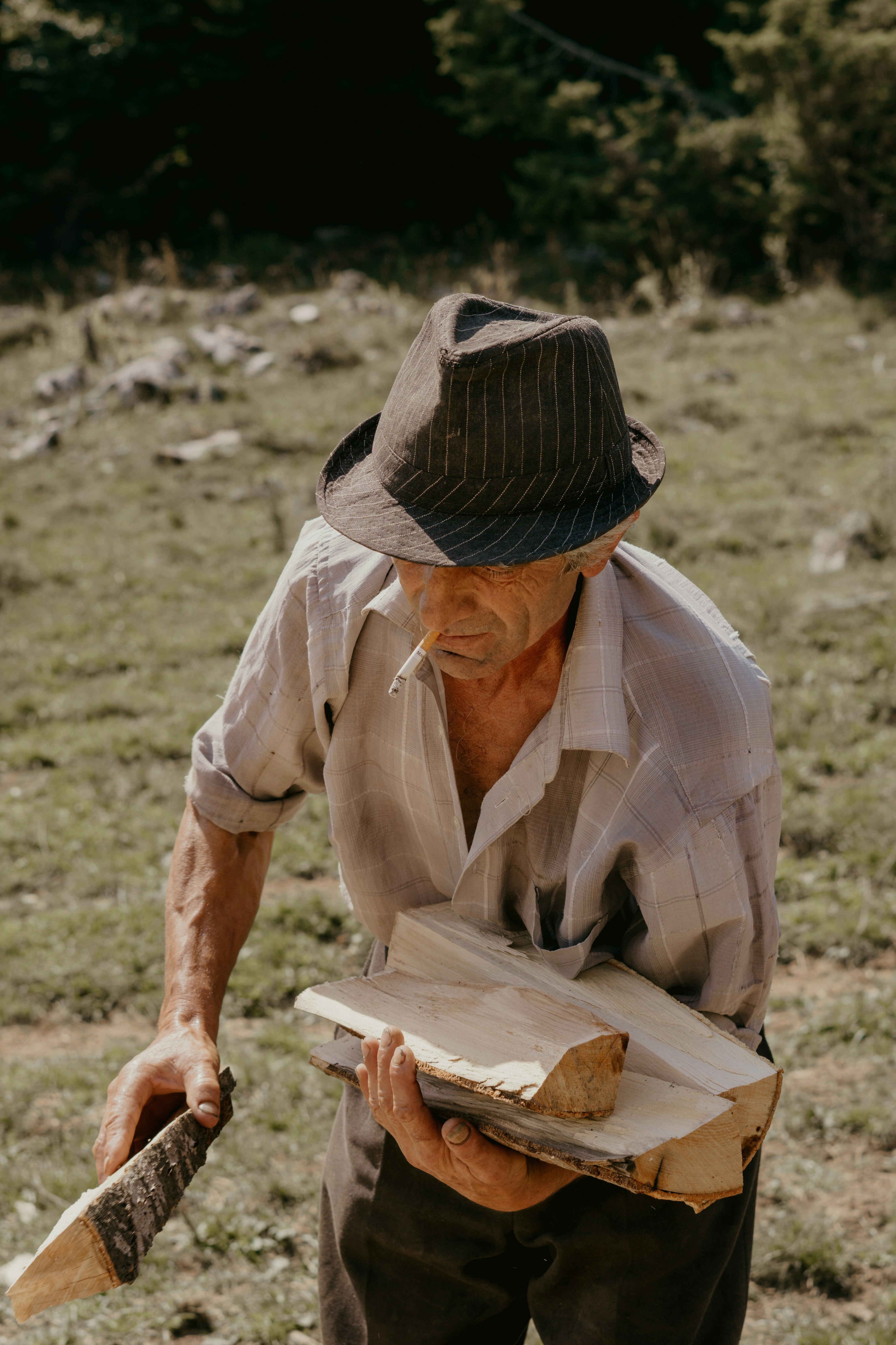 man in brown dress shirt and brown hat holding brown wooden board