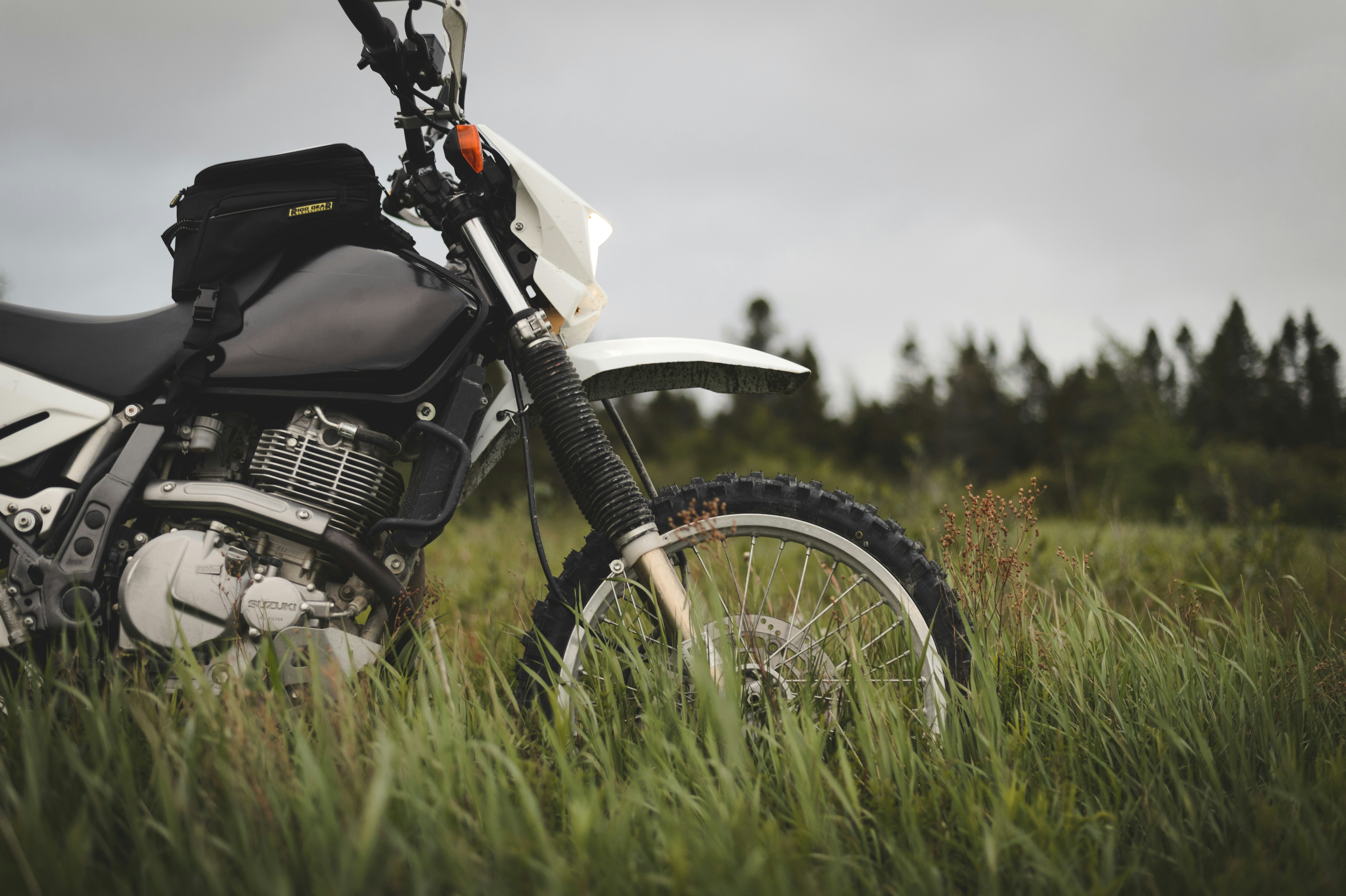 Black and white motorcycle on green grass field during daytime photo ...
