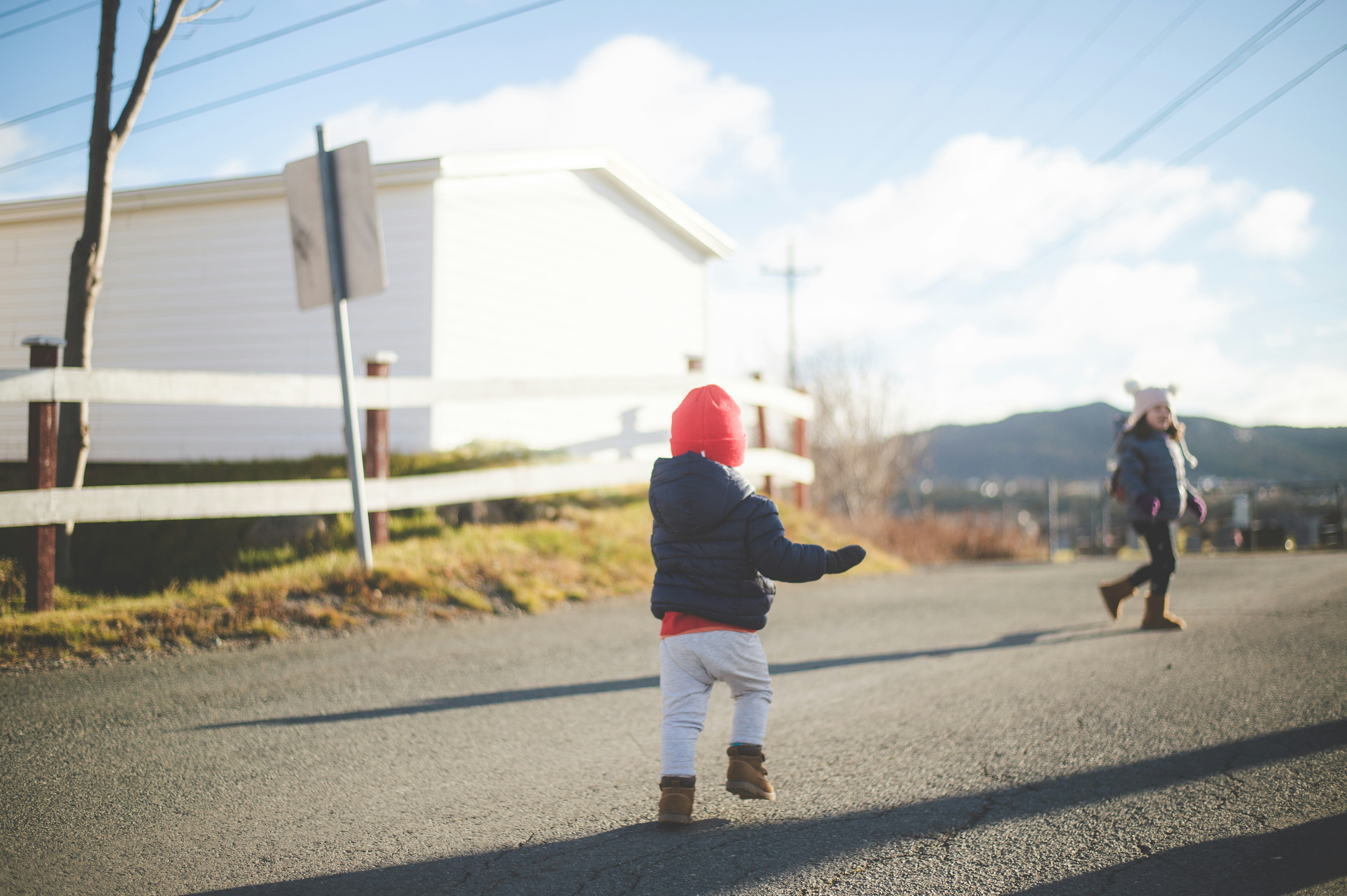 Children in motion: chasing warmth on a sunlit country road