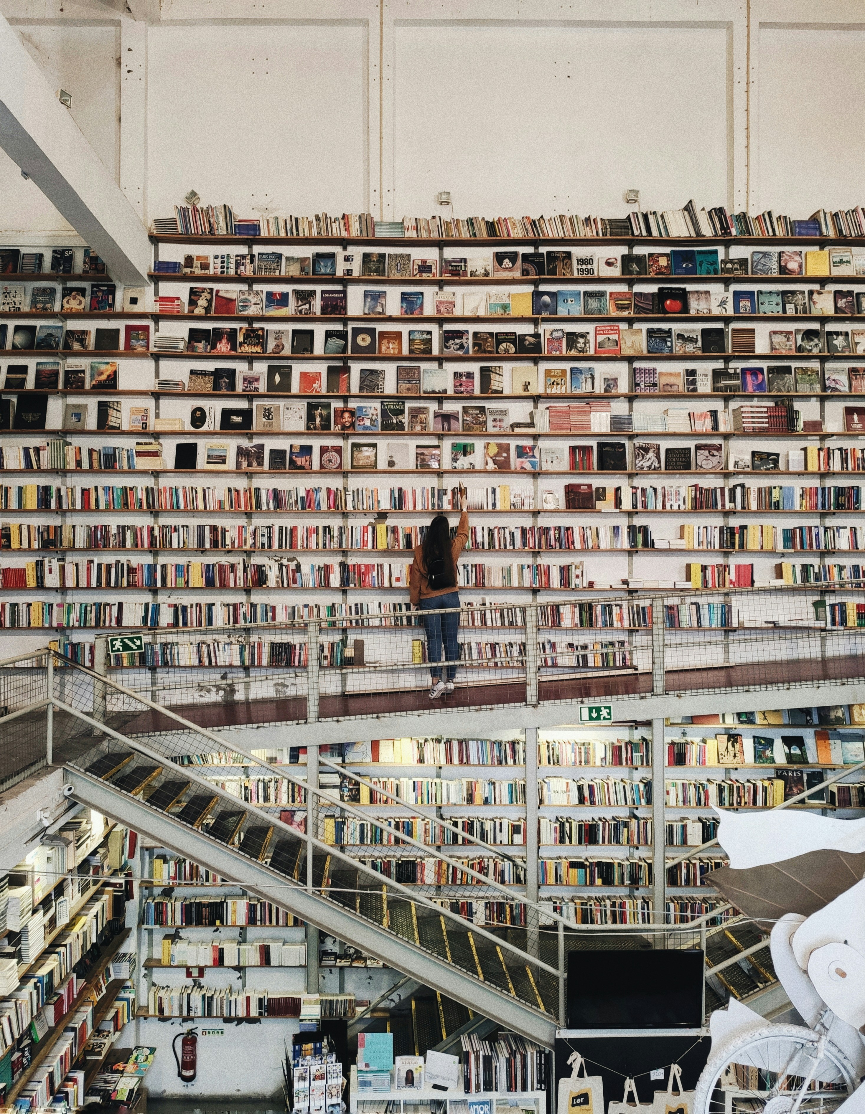 A person browsing an expansive library filled with countless books, showcasing the beauty of knowledge and exploration.