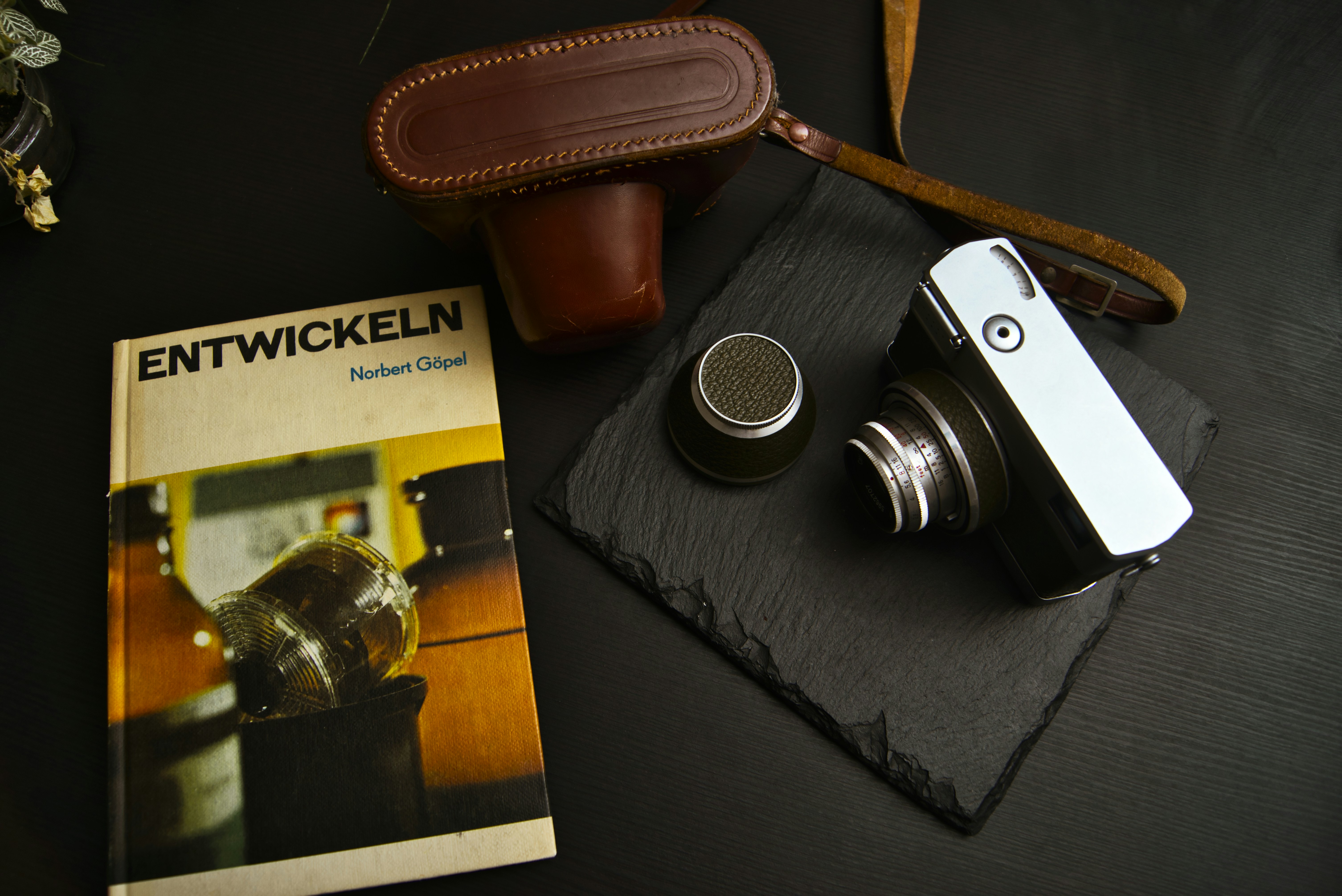 Vintage Camera Studio Still: Leather Case, Slate, and a German Development Book