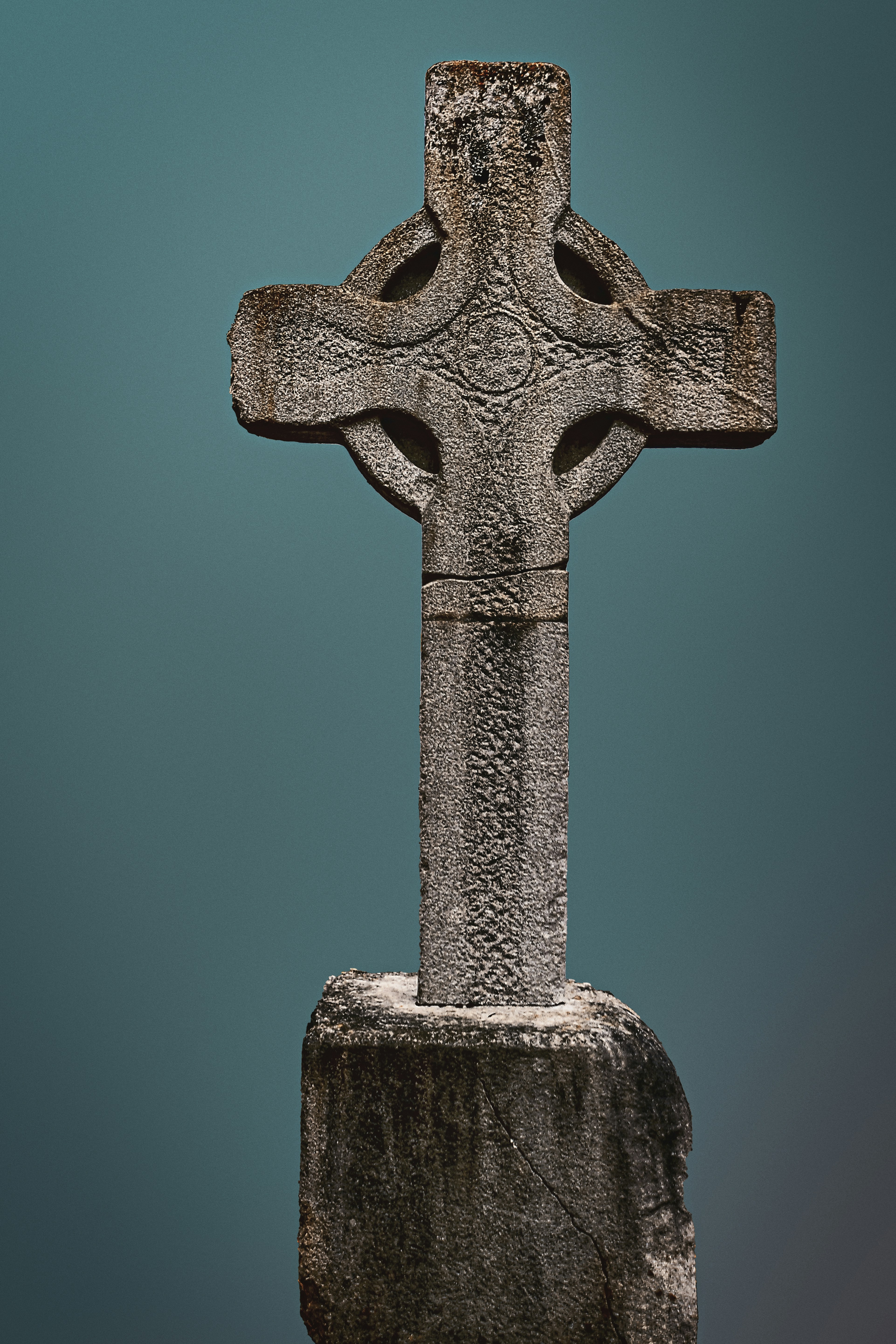 Intricately carved Celtic cross stands resilient against a serene backdrop, symbolizing heritage and spirituality.