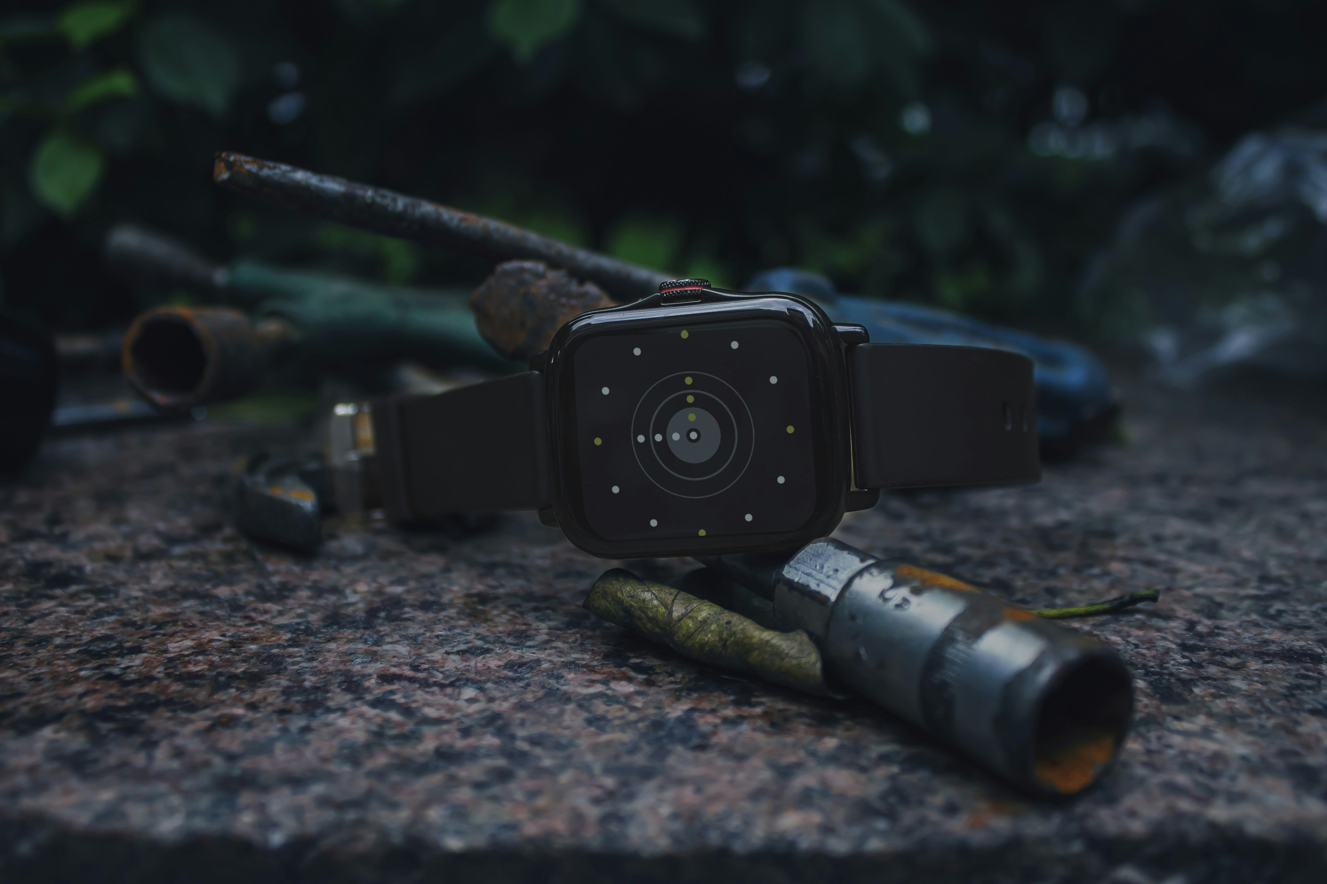 A modern smartwatch rests on a weathered surface surrounded by industrial debris, highlighting the contrast between technology and neglect.