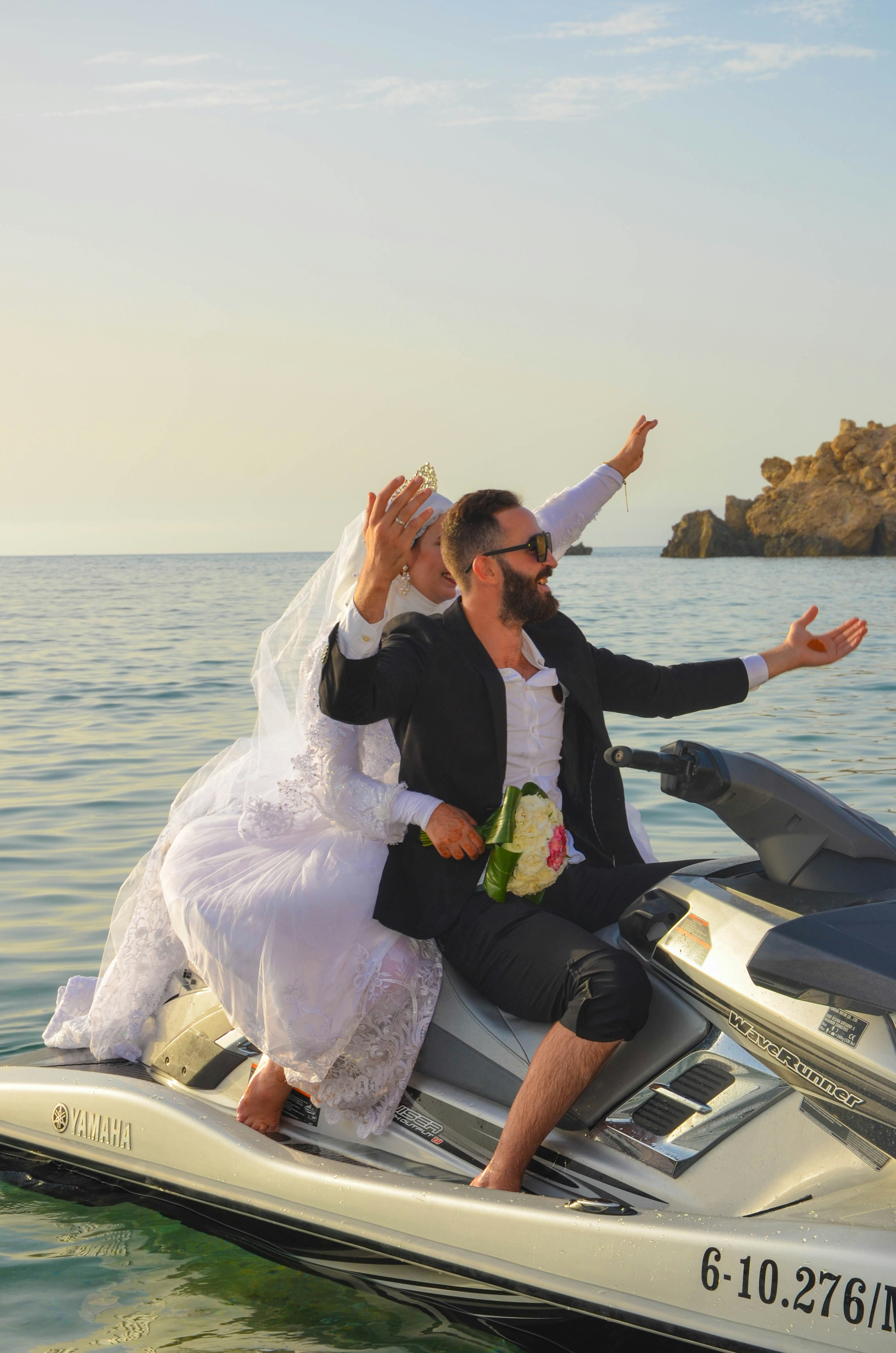 woman in white wedding gown sitting on white boat during daytime