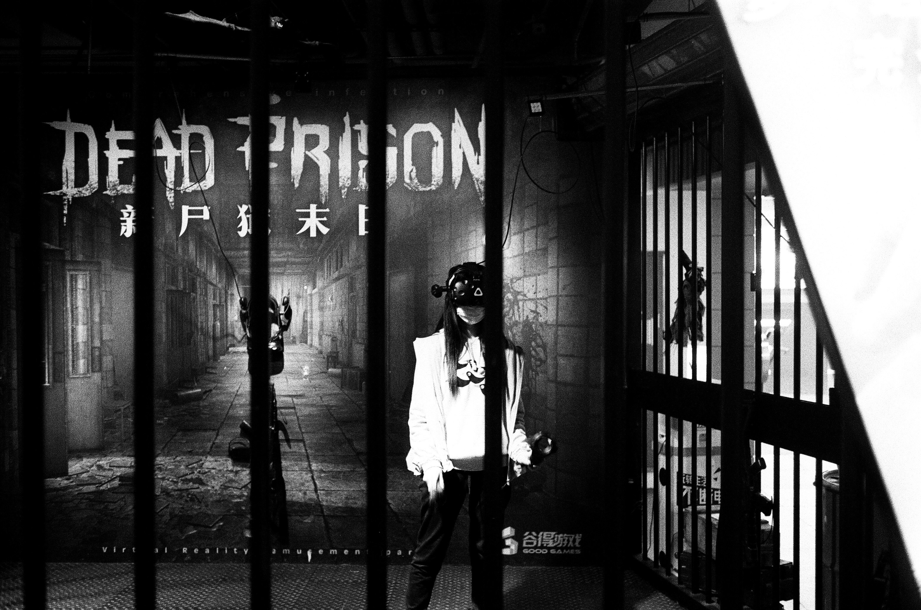 Shadowed Exhibit: A Solo Figure Behind Bars in a Monochrome Gate
