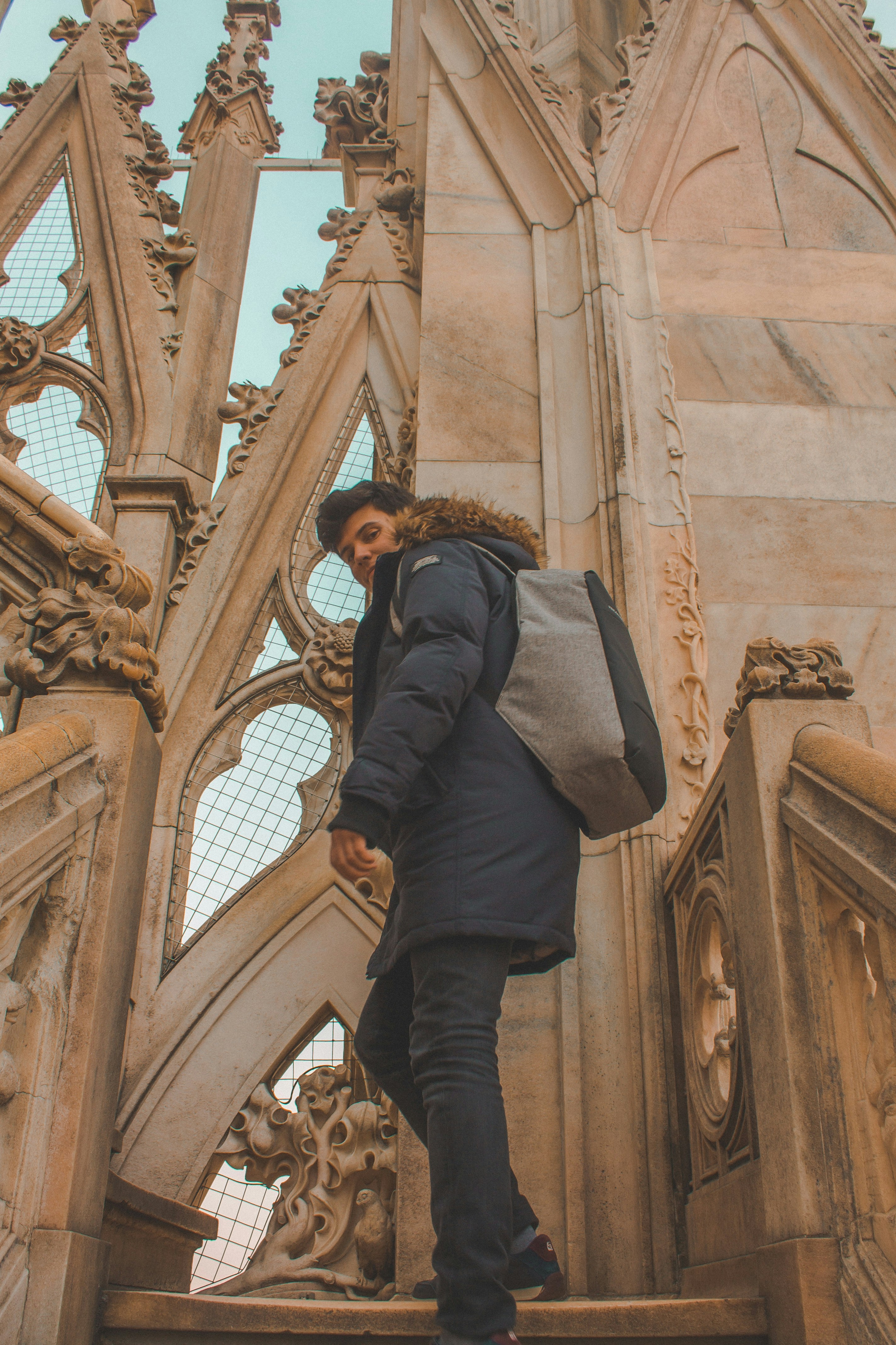 Traveler on Gothic Staircase: A Quiet Ascent Beneath Stone Arches