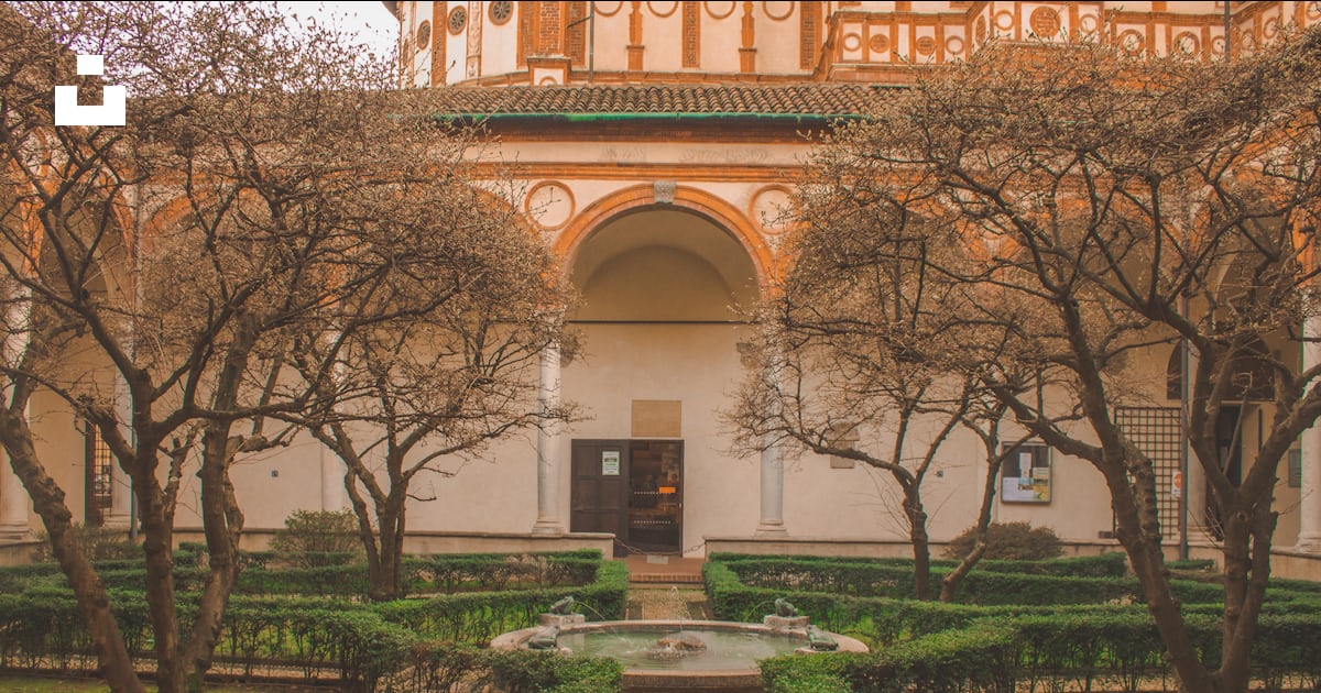 昼間は緑の芝生や木々の近くにある茶色のコンクリートの建物の写真 Unsplashの旅行の無料画像