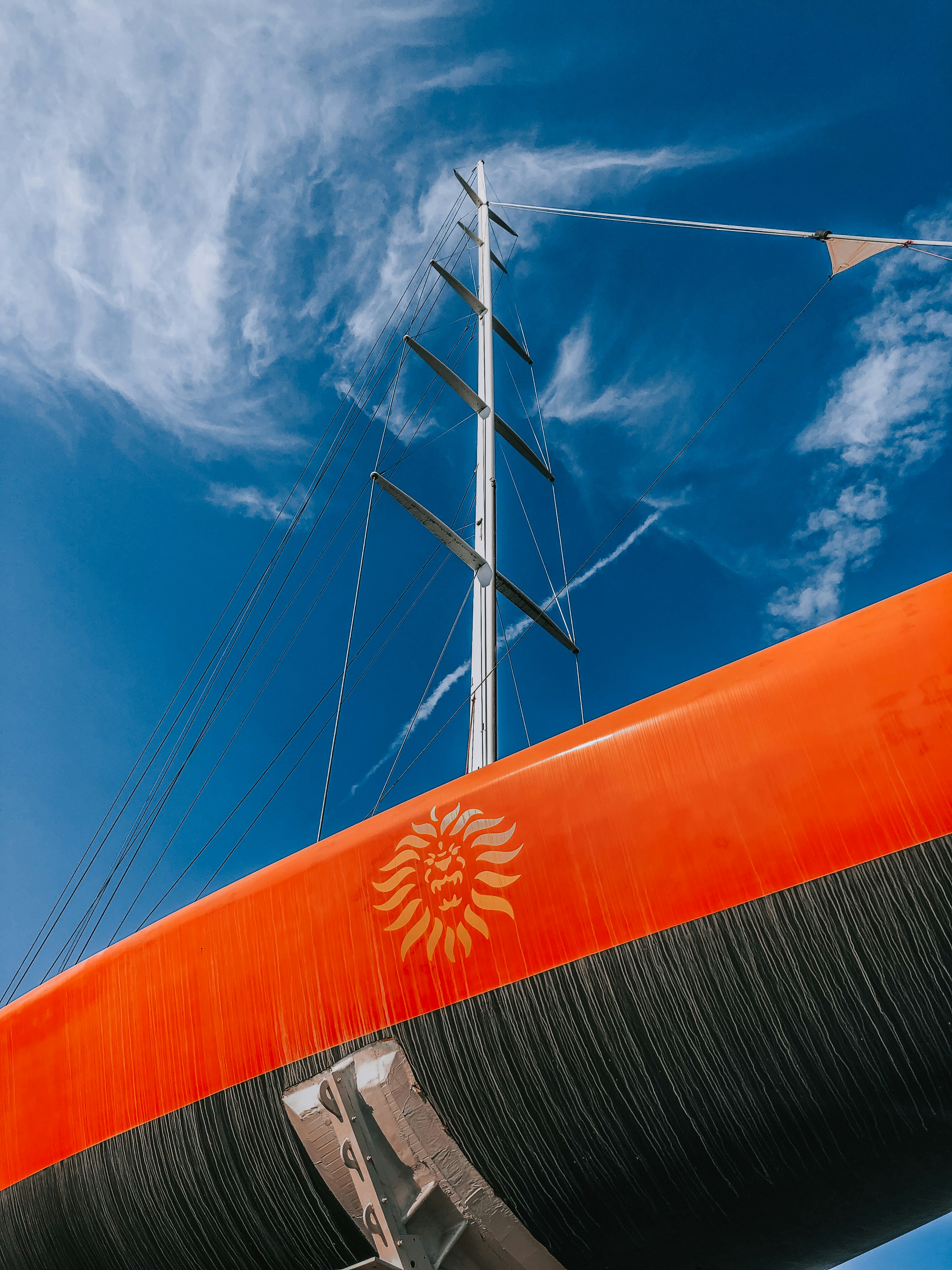 Sunburst on Orange Sail: Mast Pierces the Cerulean Sky