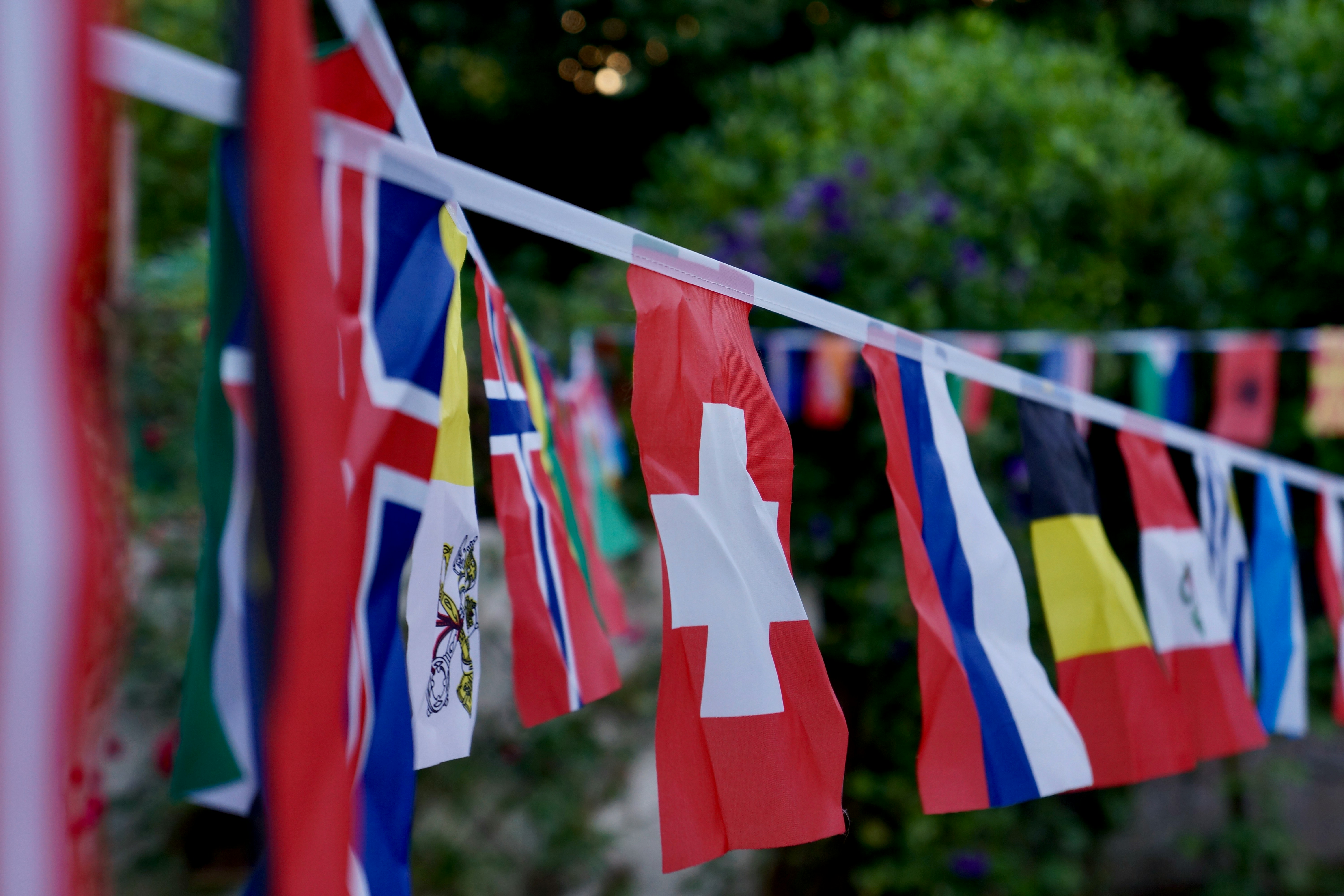 Swiss Flag at the Heart of a Global Flag Garland in a Garden