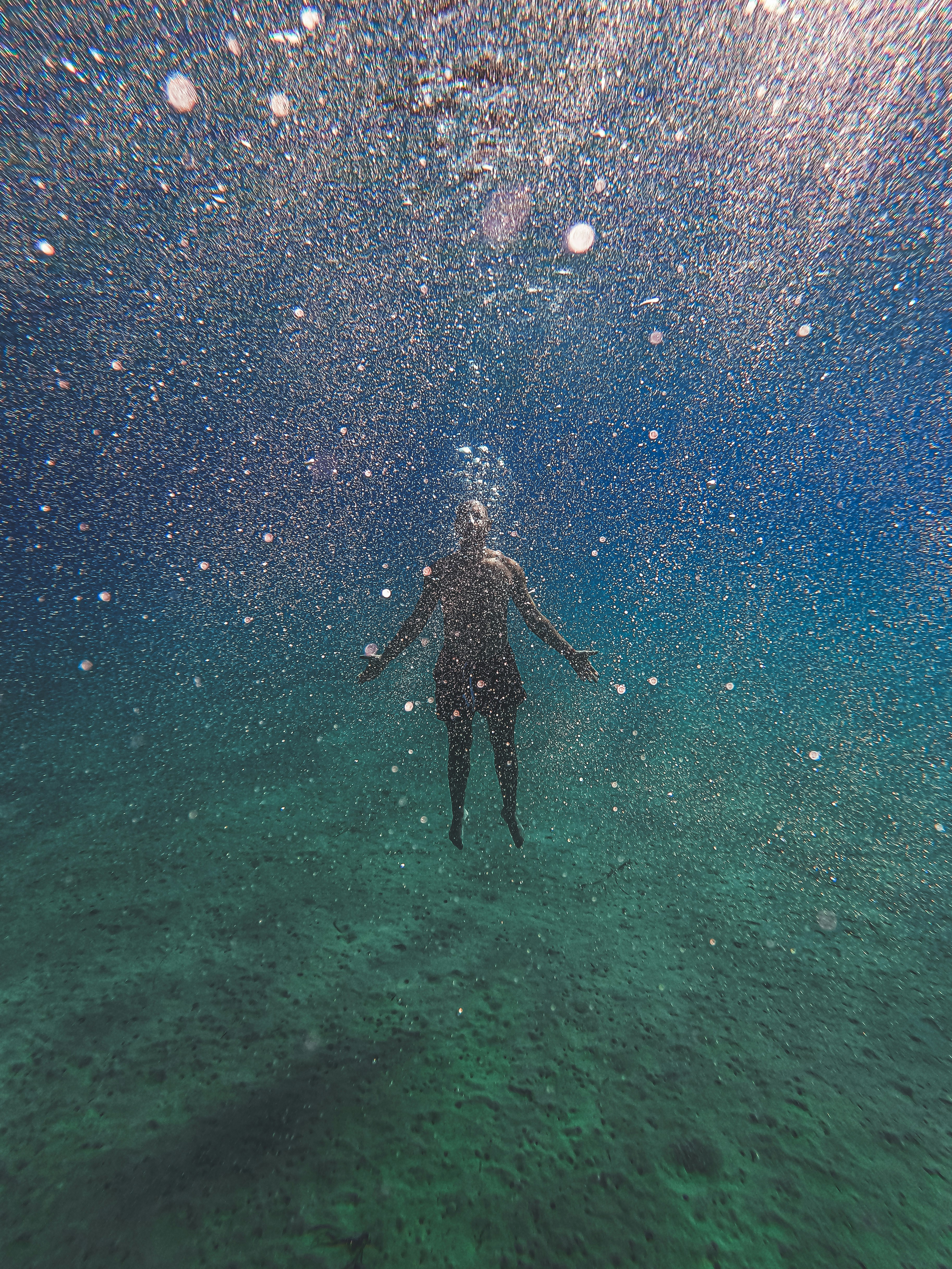 Bubblebound Solitude: A Figure Drifts in Turquoise Depths