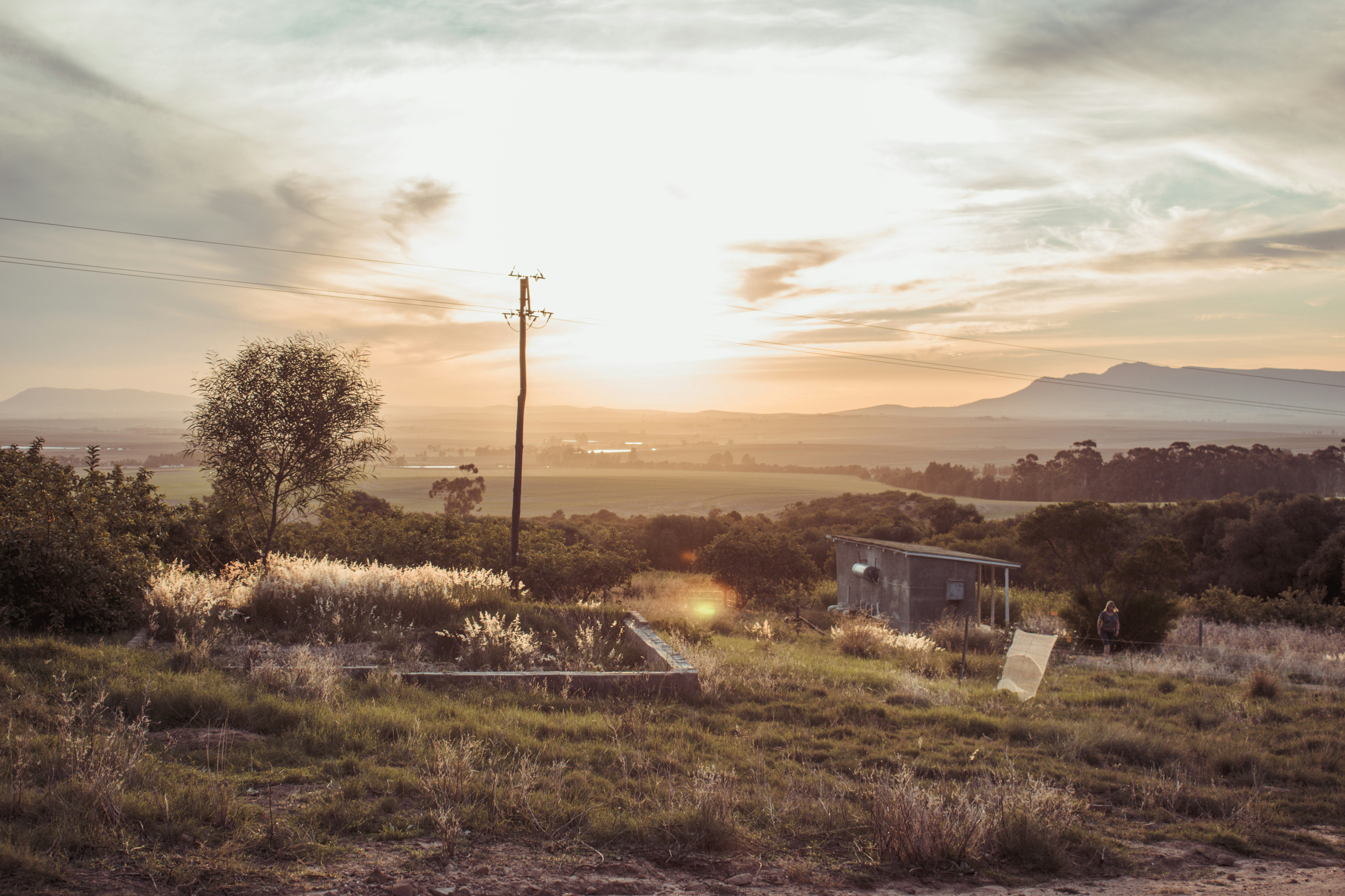white and brown house near green grass field during sunset