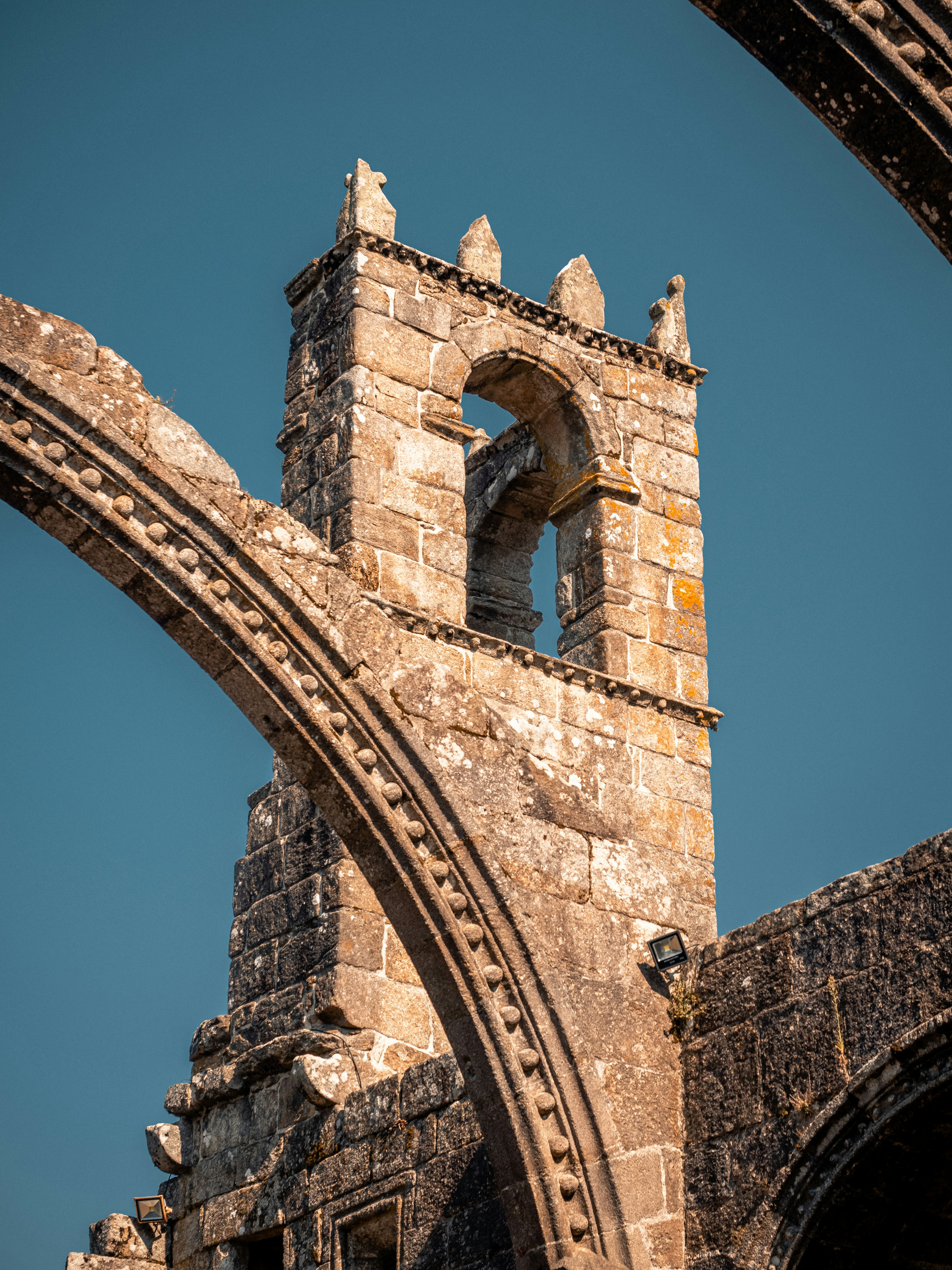 Bell-Tower Remnant under Archway: Weathered Stone Eyes the Sky
