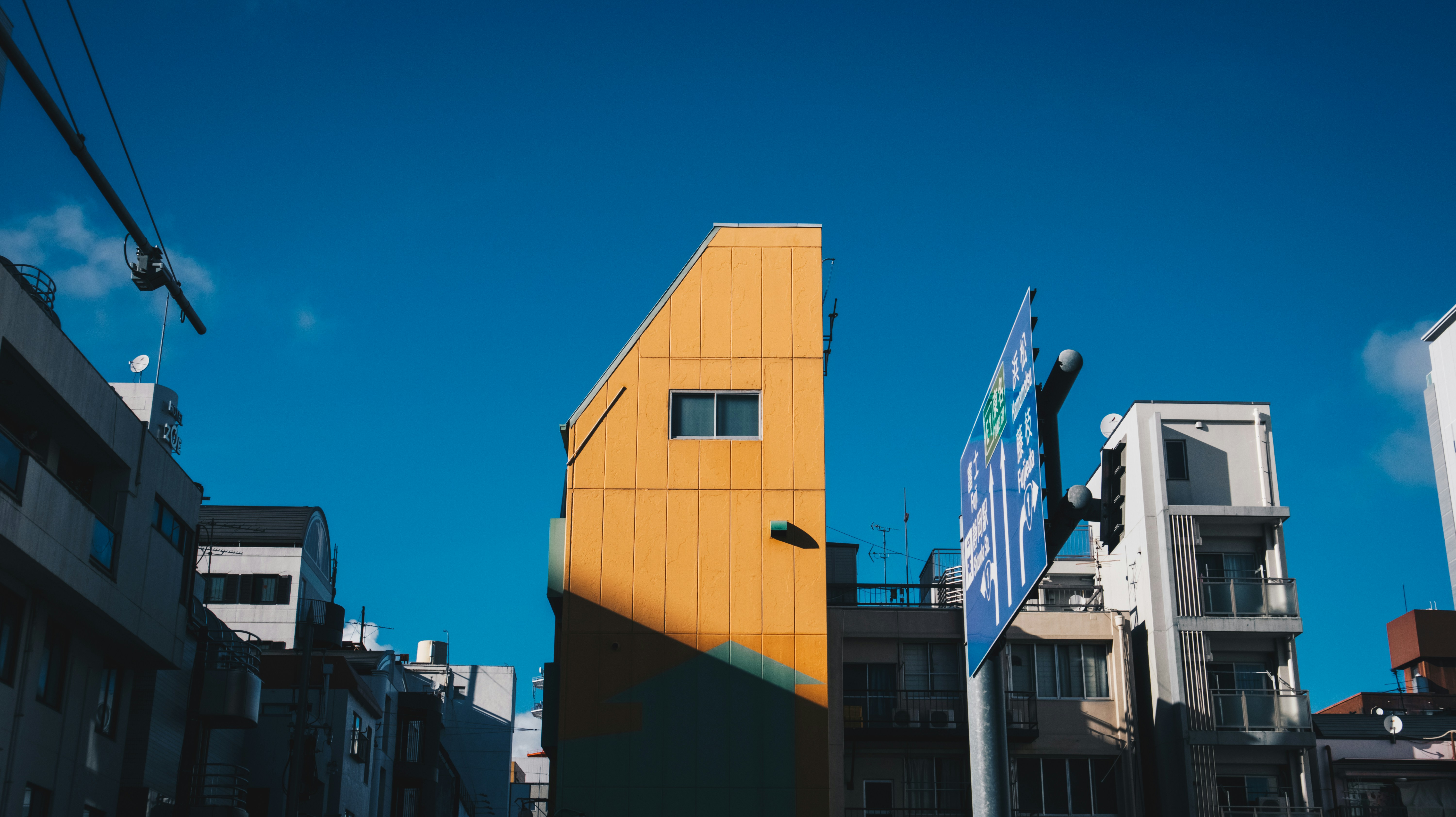 Orange Facade Rising Through a Crisp Blue City Sky