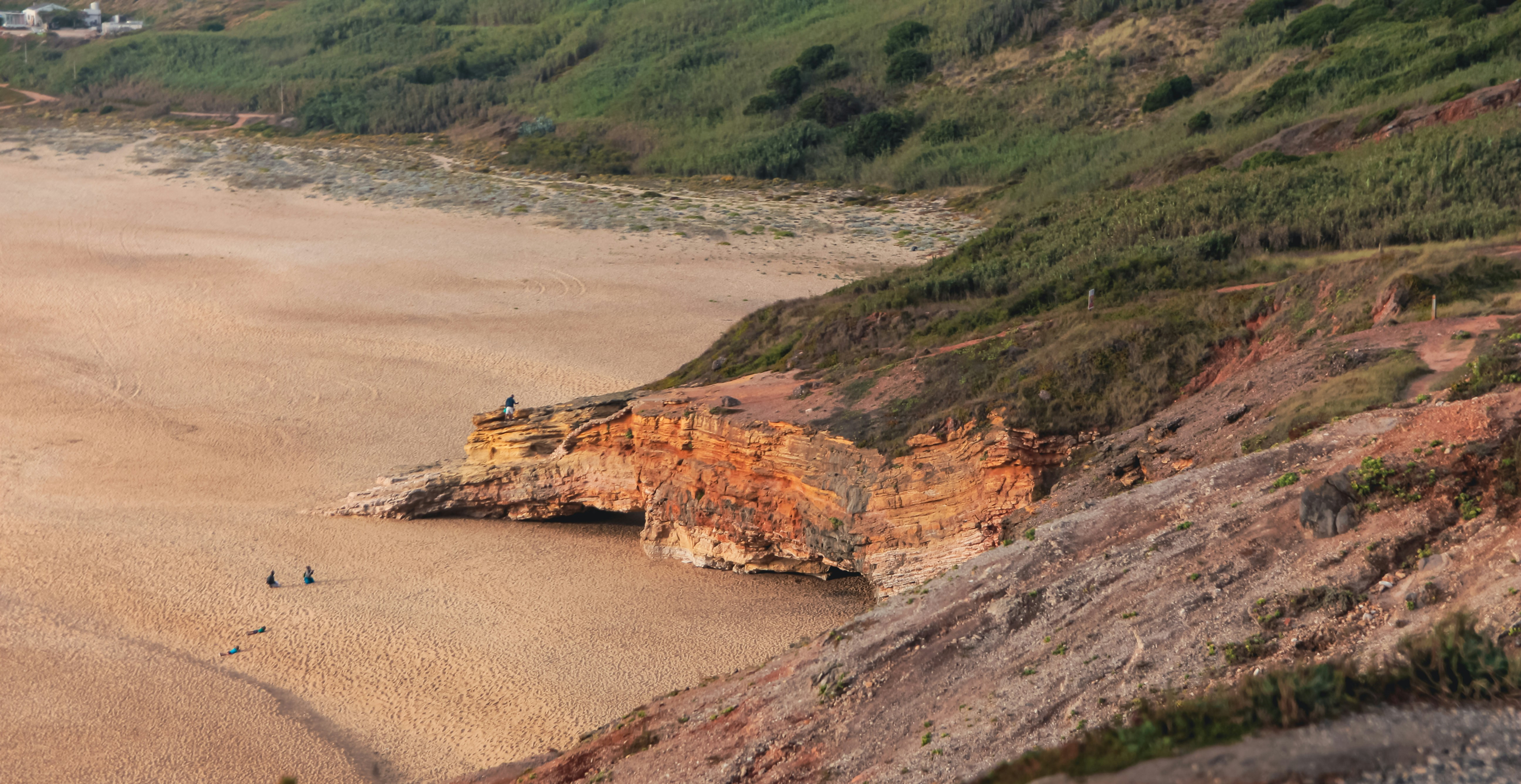 Sunlit Cliffside Reveal over a Quiet Curved Beach