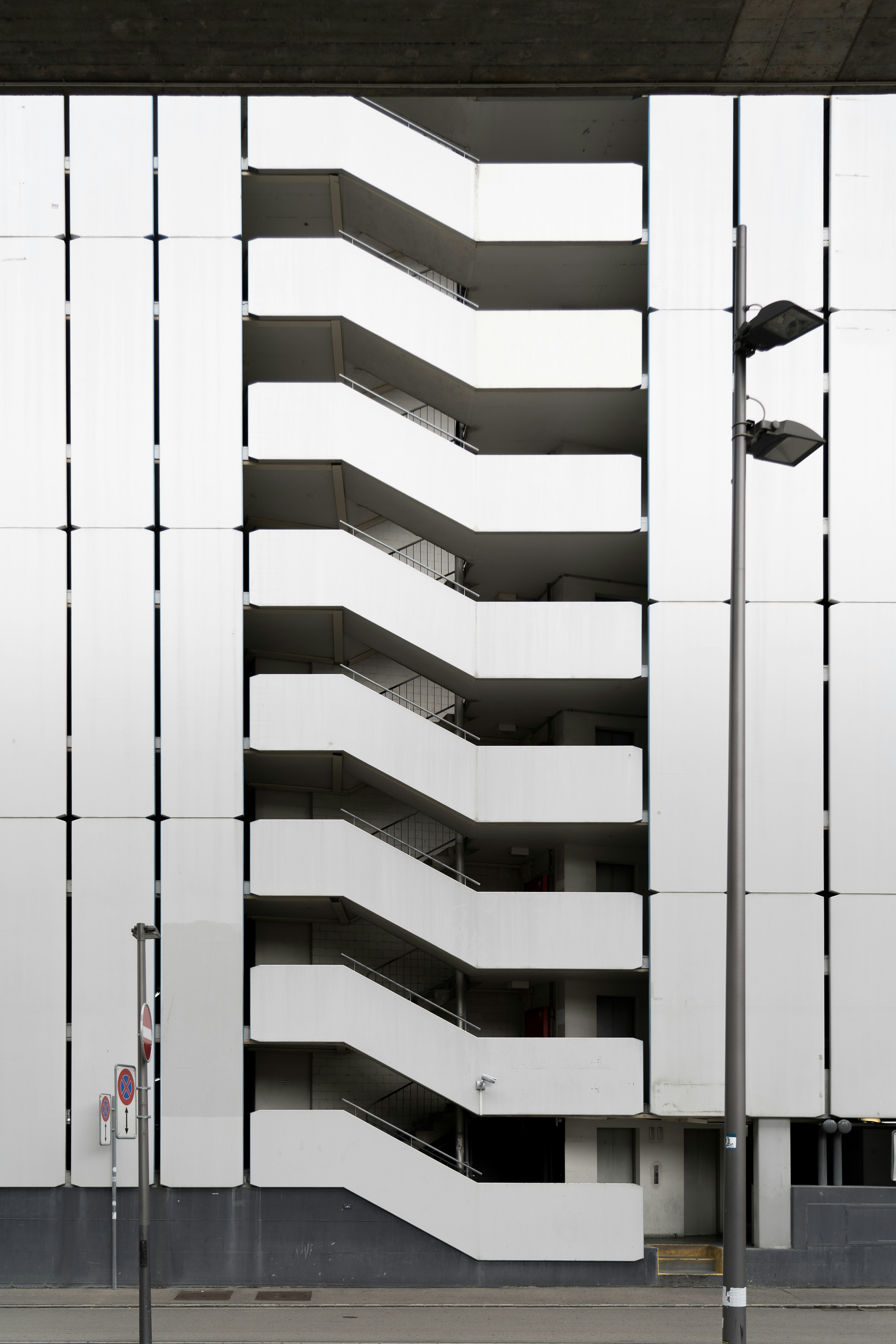 Zigzag Echoes on a White Parking Facade: Staircase Geometry in Monochrome