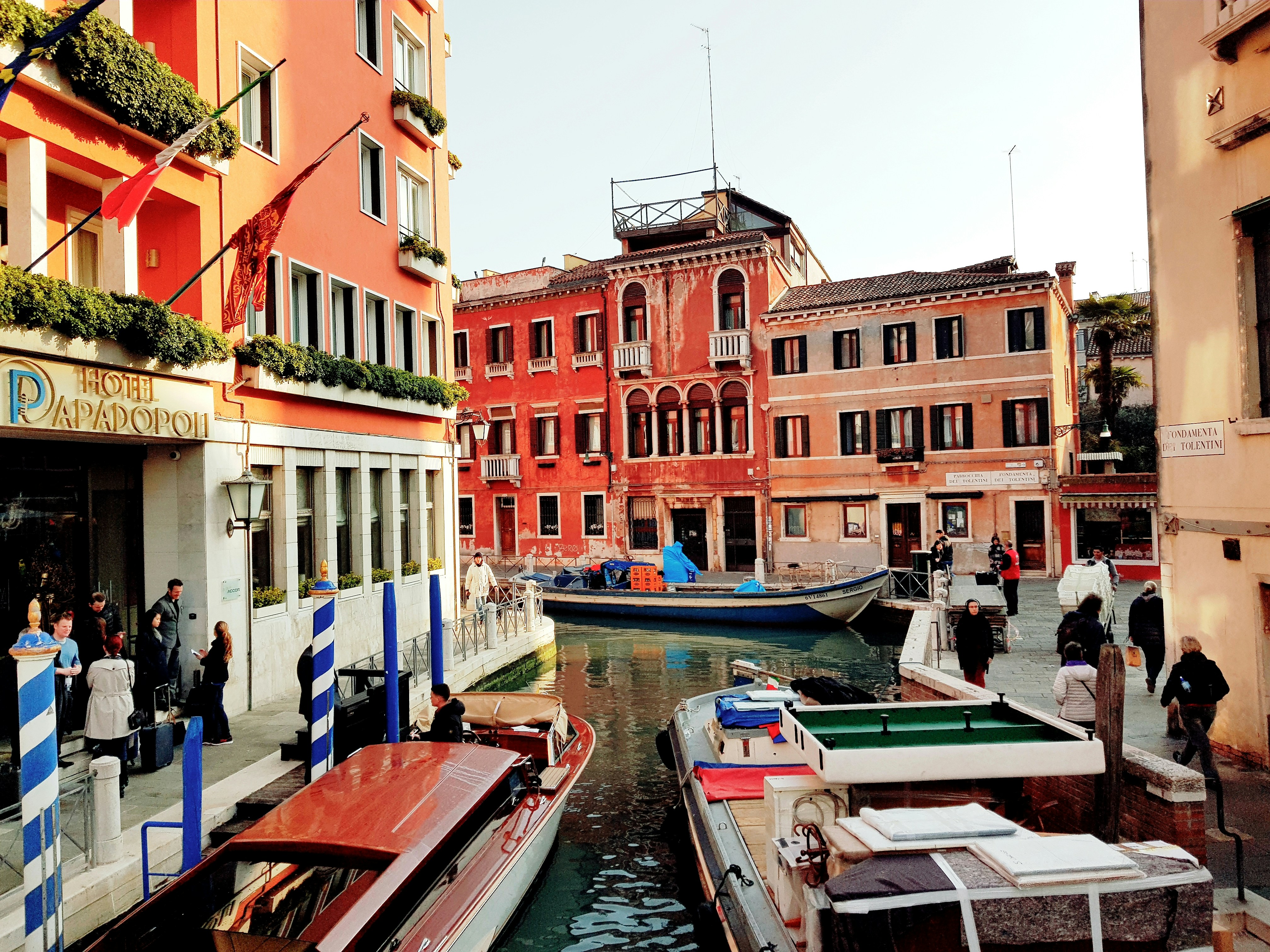 People walking on sidewalk near river with boats during daytime photo ...