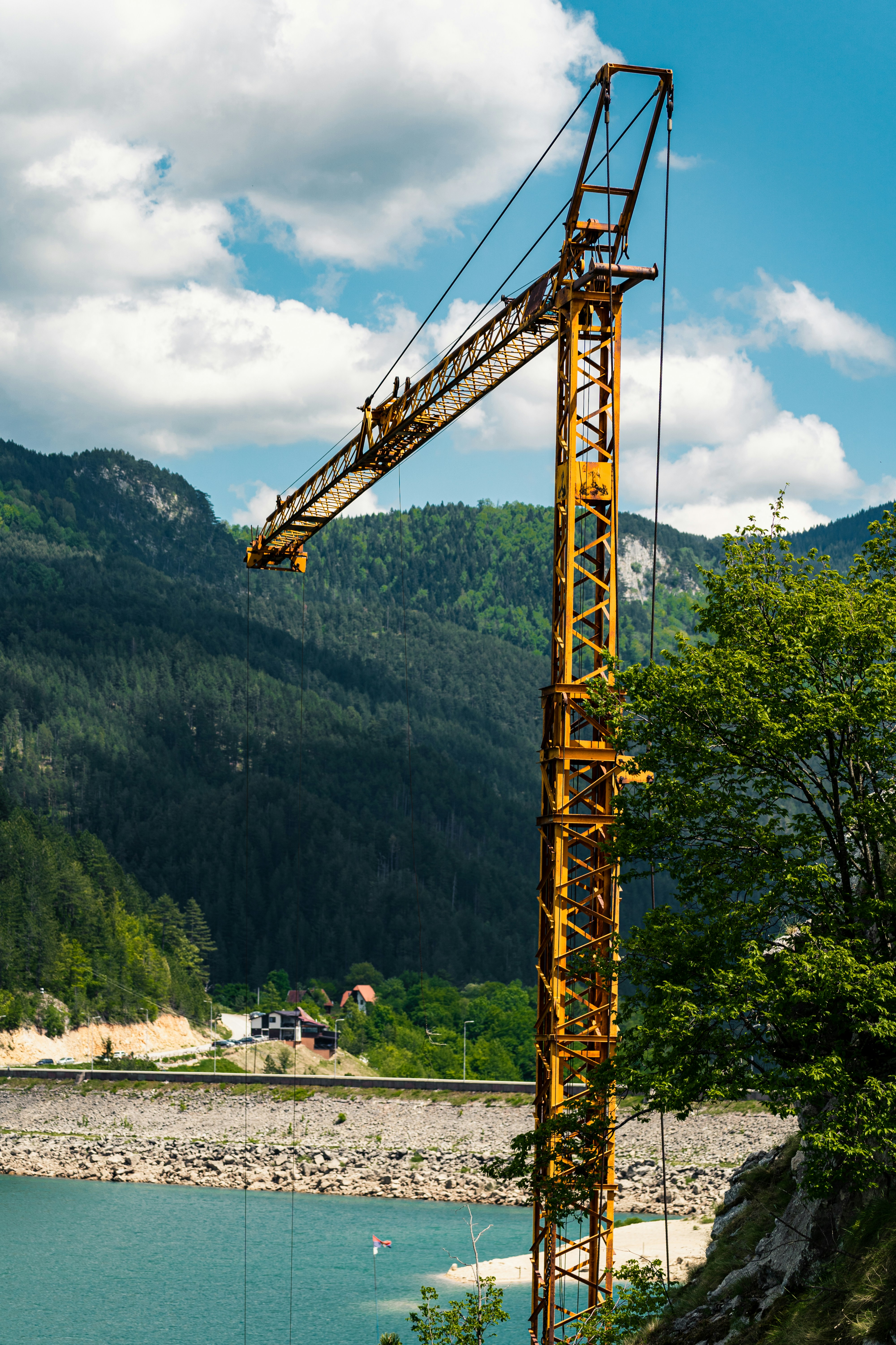 Rusted Crane Against Alpine Lake: A Towering Glint of Steel