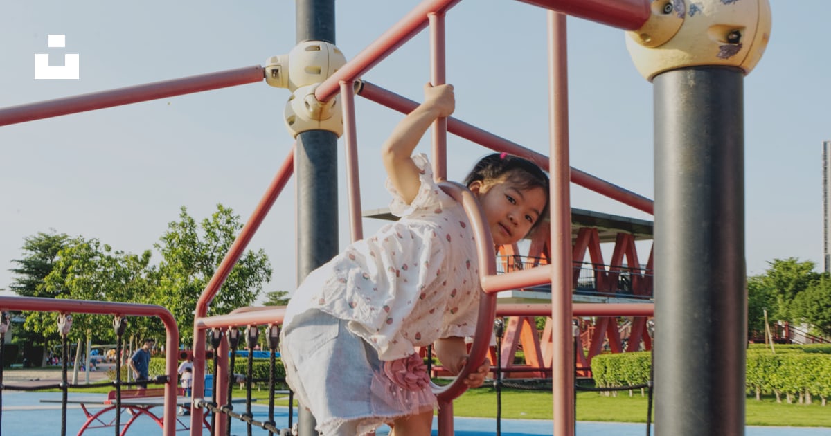 흰색과 회색 꽃 드레스를 입은 소녀가 빨간 금속 막대에 서 있습니다 사진 Unsplash의 무료 광저우 이미지