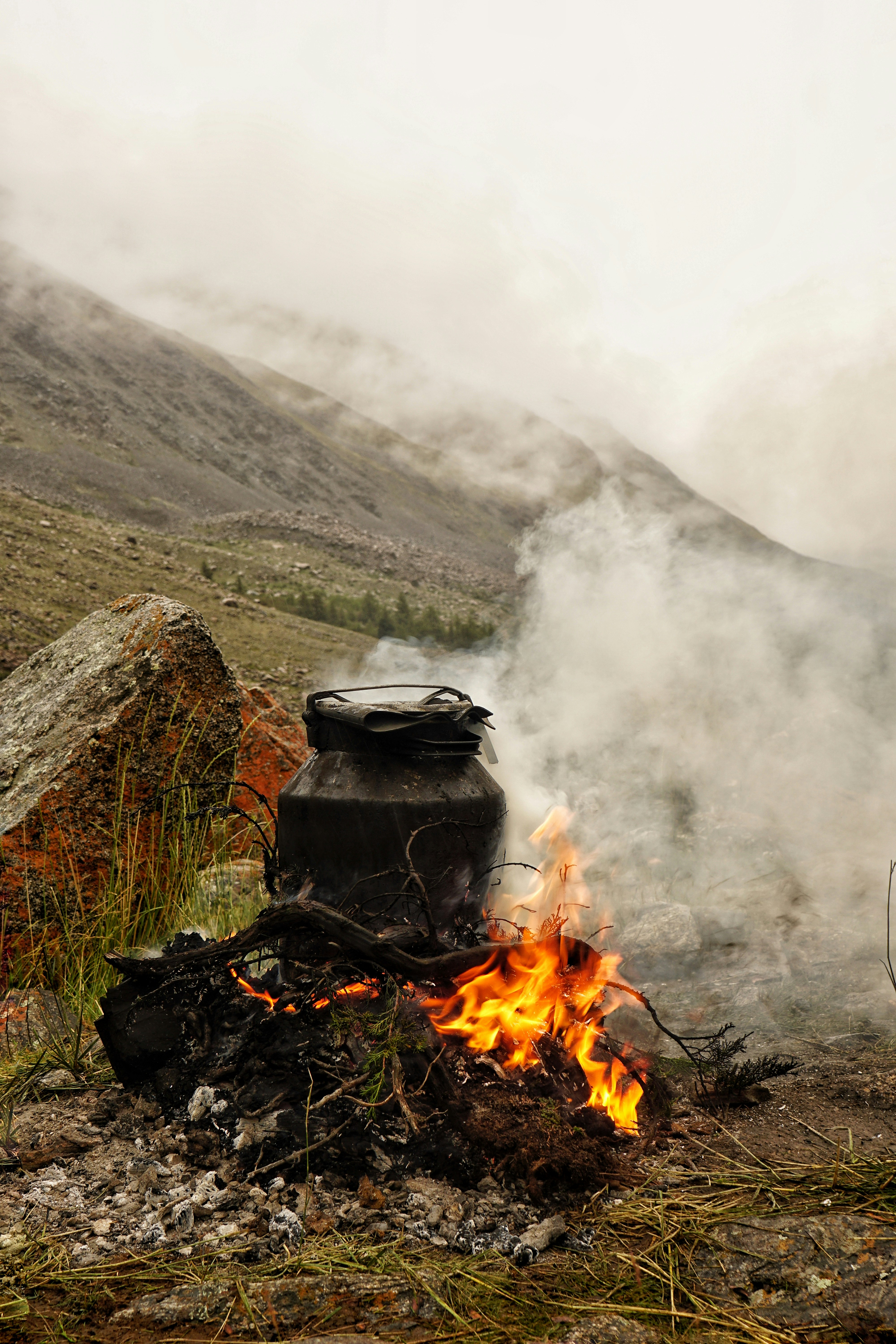 Kettle Ember on a Mountain Campfire Beneath Alpine Mist