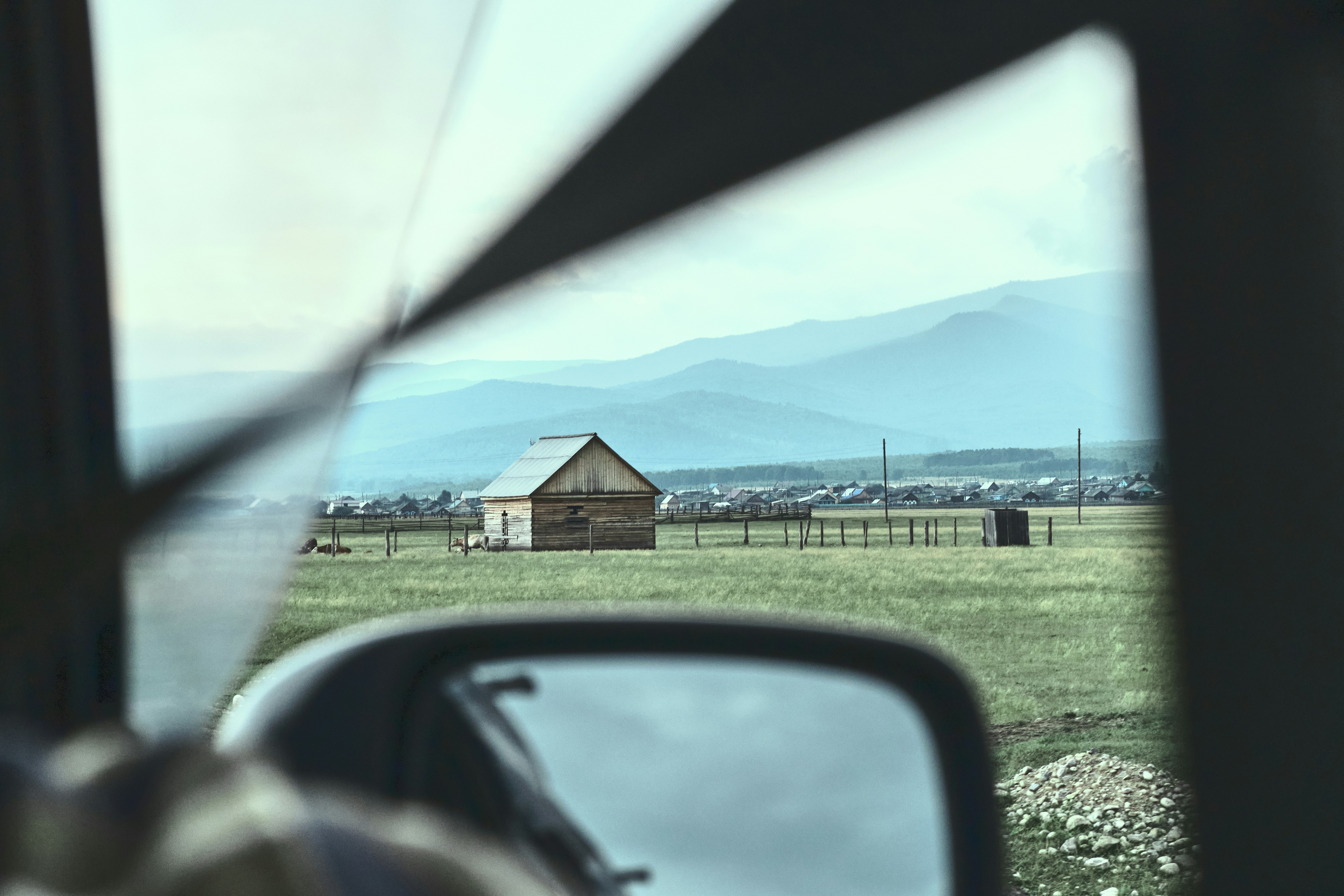 Horizon Barn Framed by Mountain Mist: A Quiet Car Window View