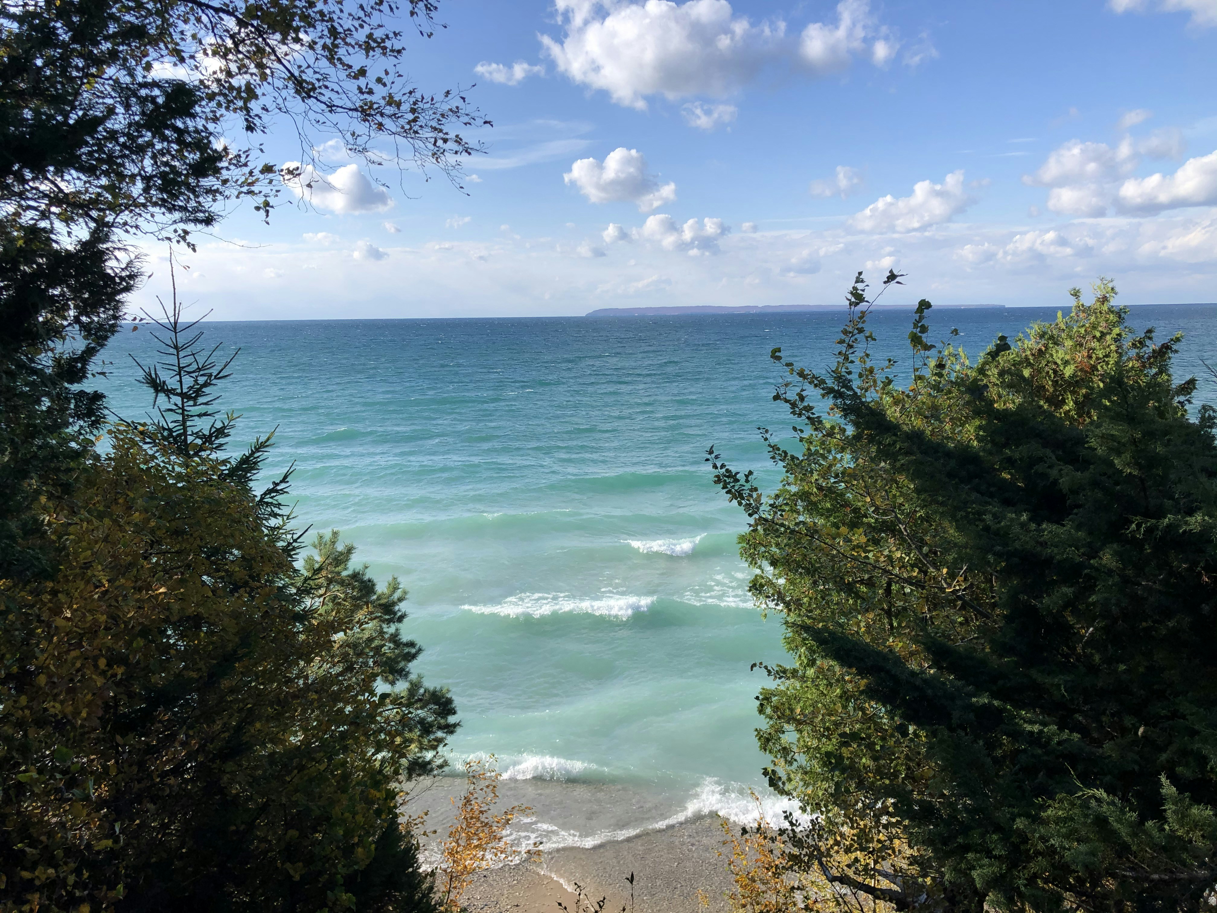 Lake Michigan near South Manitou island. | green trees near blue sea under blue sky during daytime