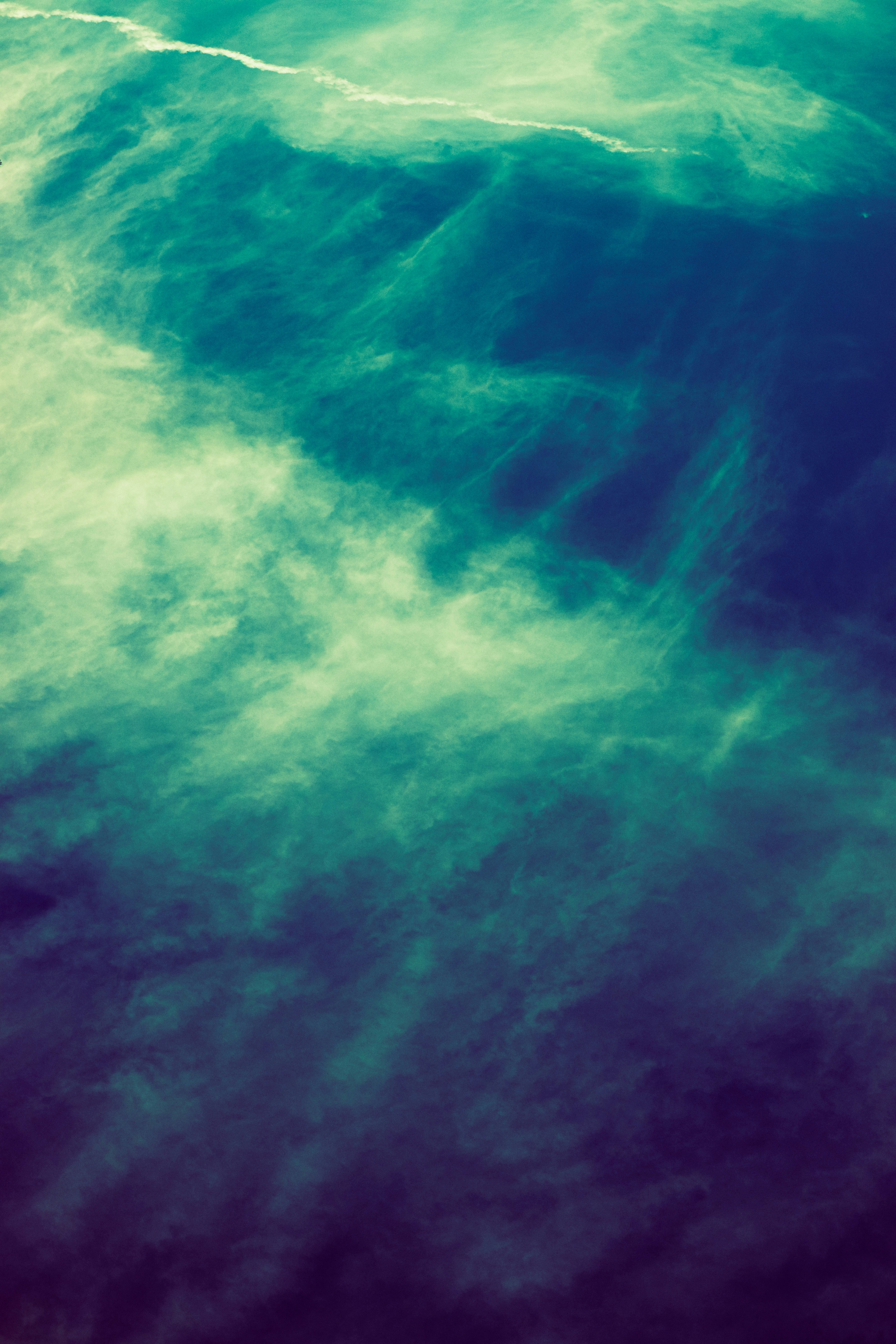 Abstract representation of swirling clouds in shades of blue and green, evoking a sense of tranquility and depth.