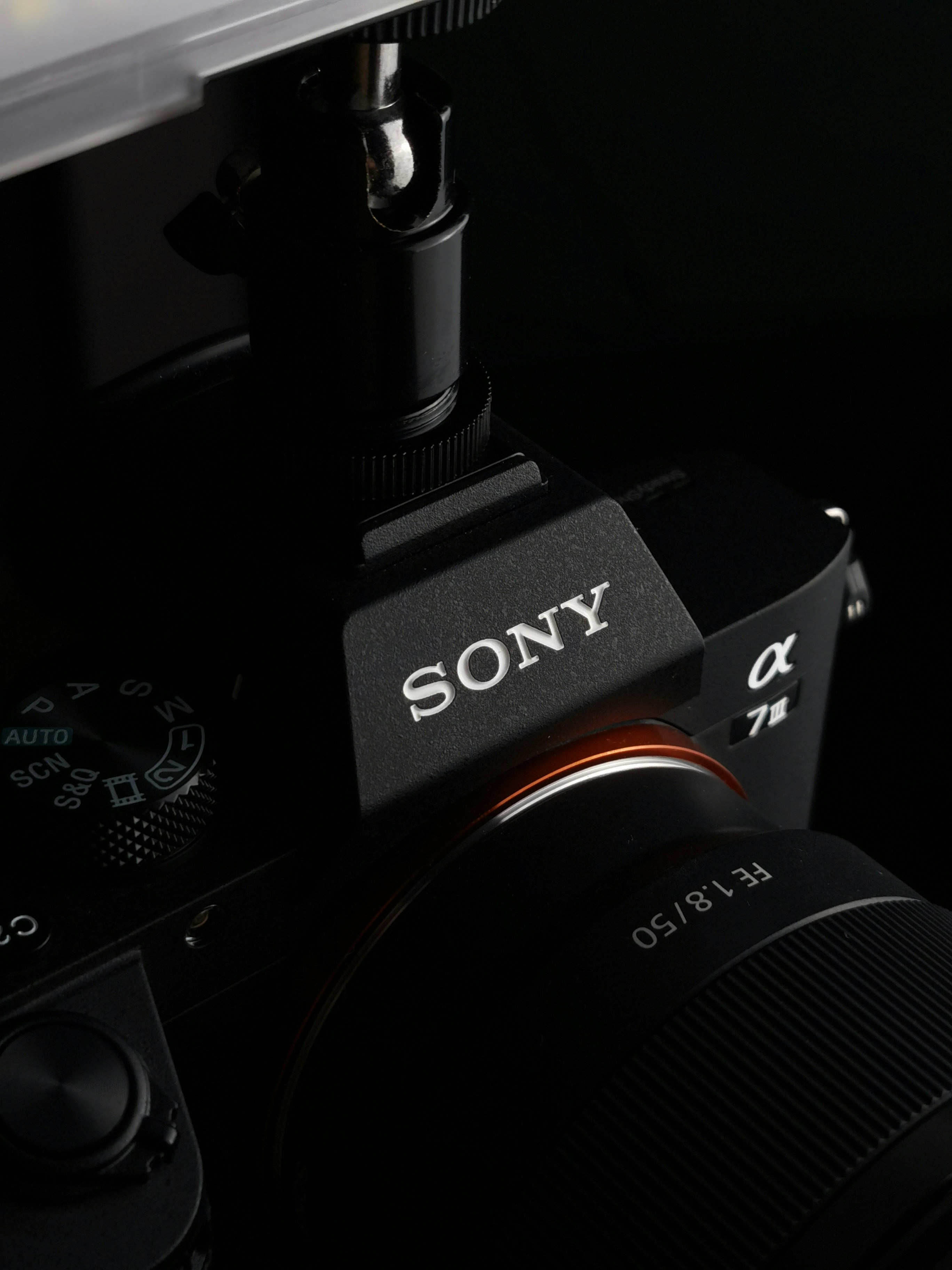 Photograph of a Sony Alpha camera body with lens, highlighting branding and the tactile metal finish.