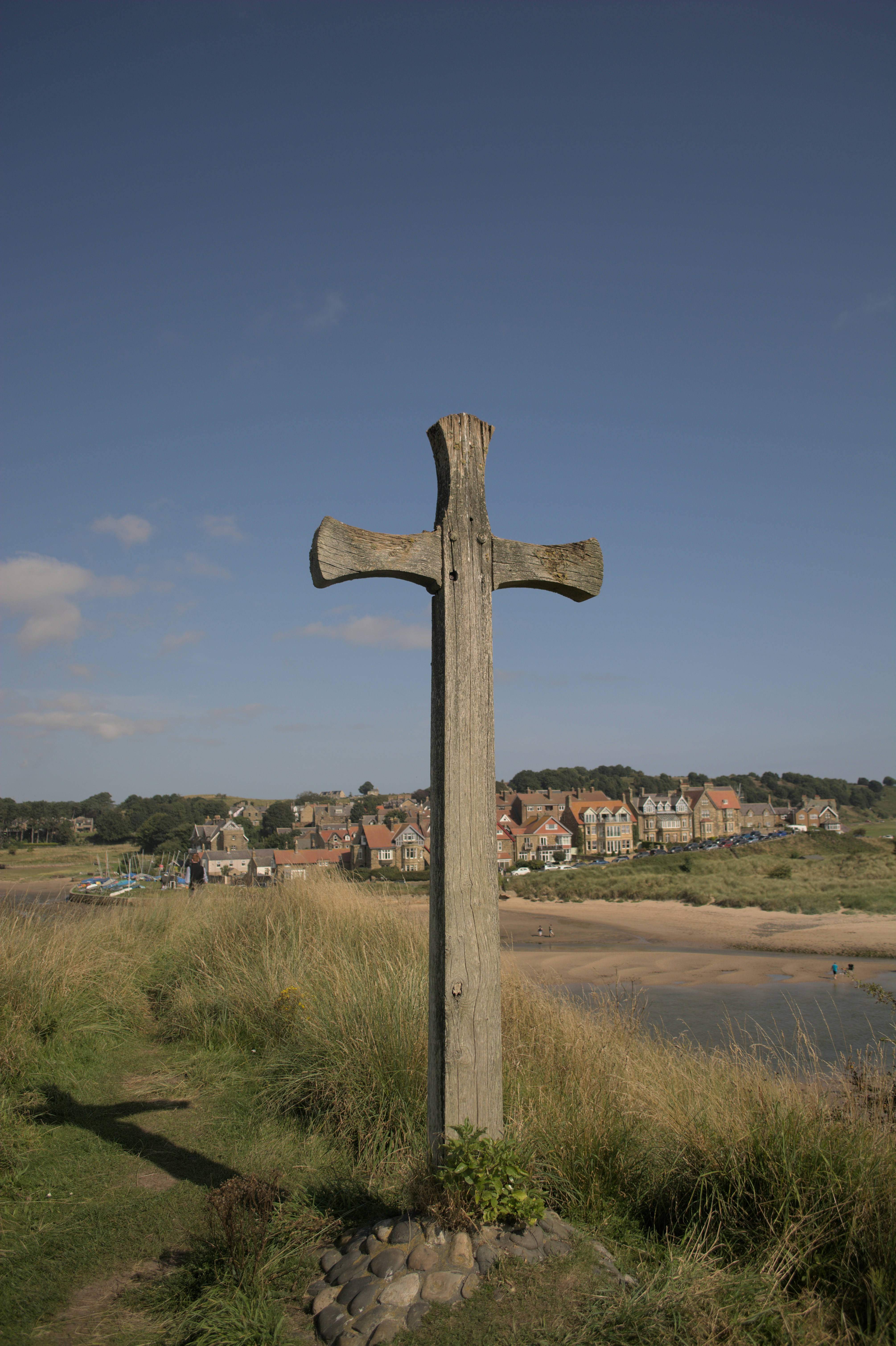 Lone Coastal Cross Overlooking a Quiet Village by the Sea