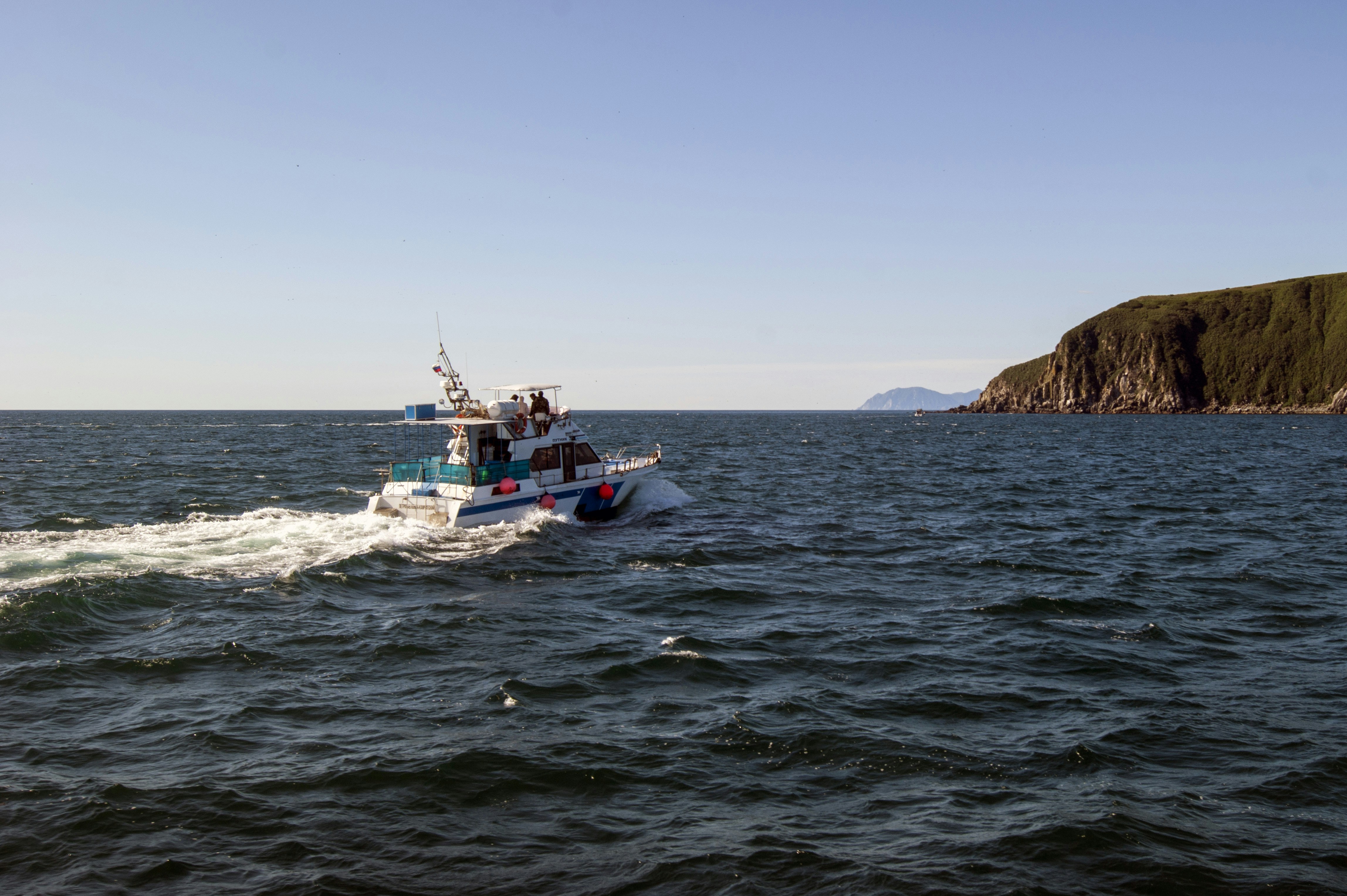 Toward the Horizon: A Bright Boat Cutting the Quiet Sea