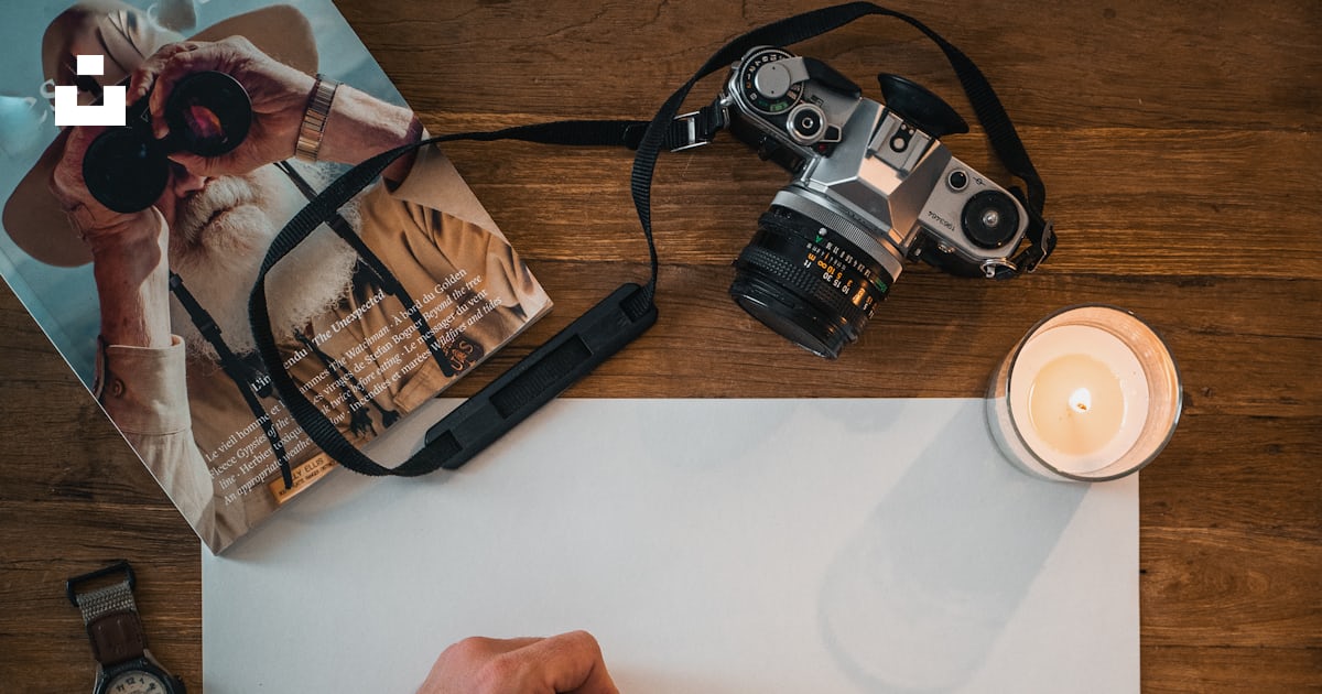 검은색 Dslr 카메라와 흰색 세라믹 머그잔 근처에 흰색 프린터 용지를 들고 있는 사람 사진 Unsplash의 무료 위에서