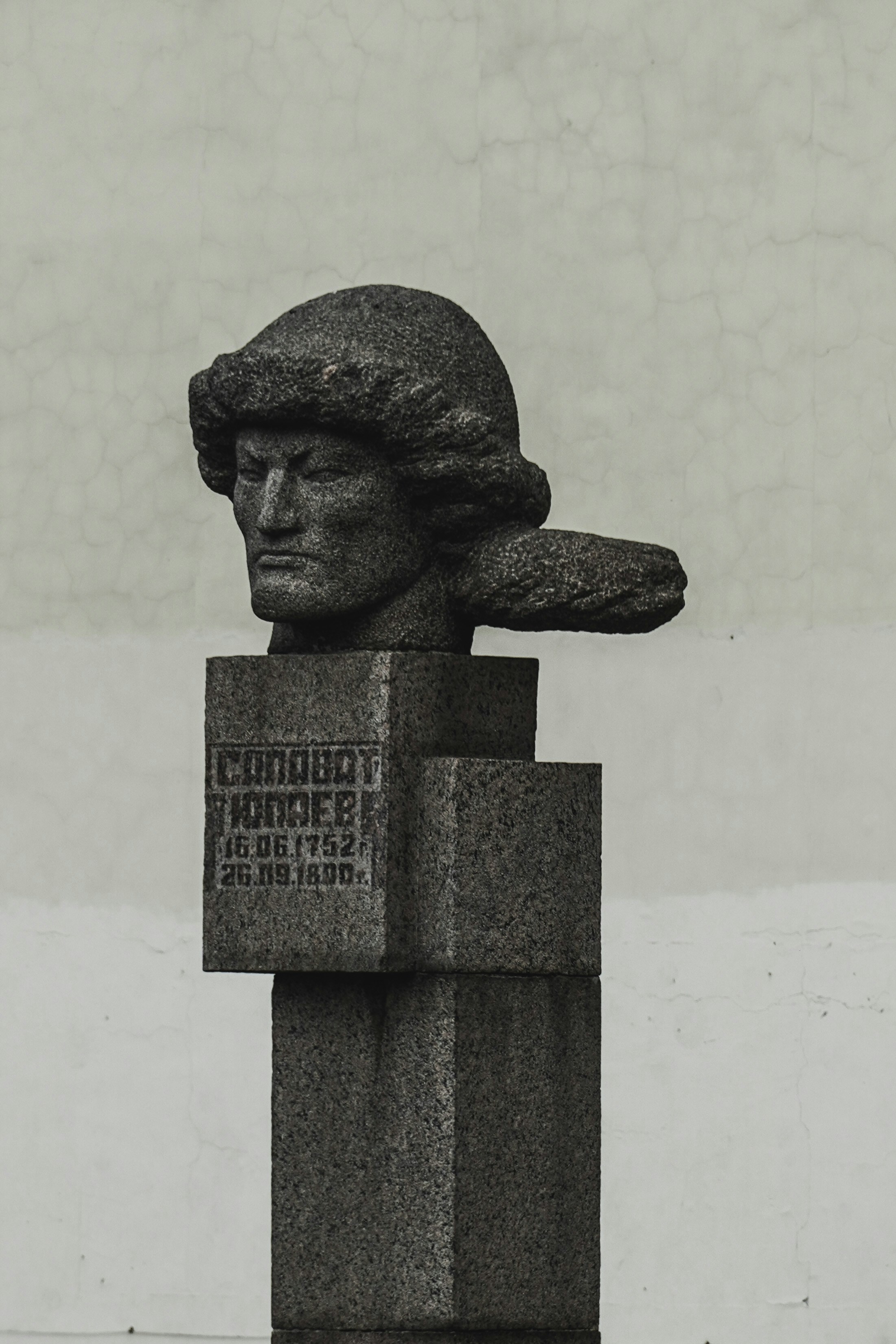 Weathered Bust: A Quiet Sentinel on a Tiered Pedestal