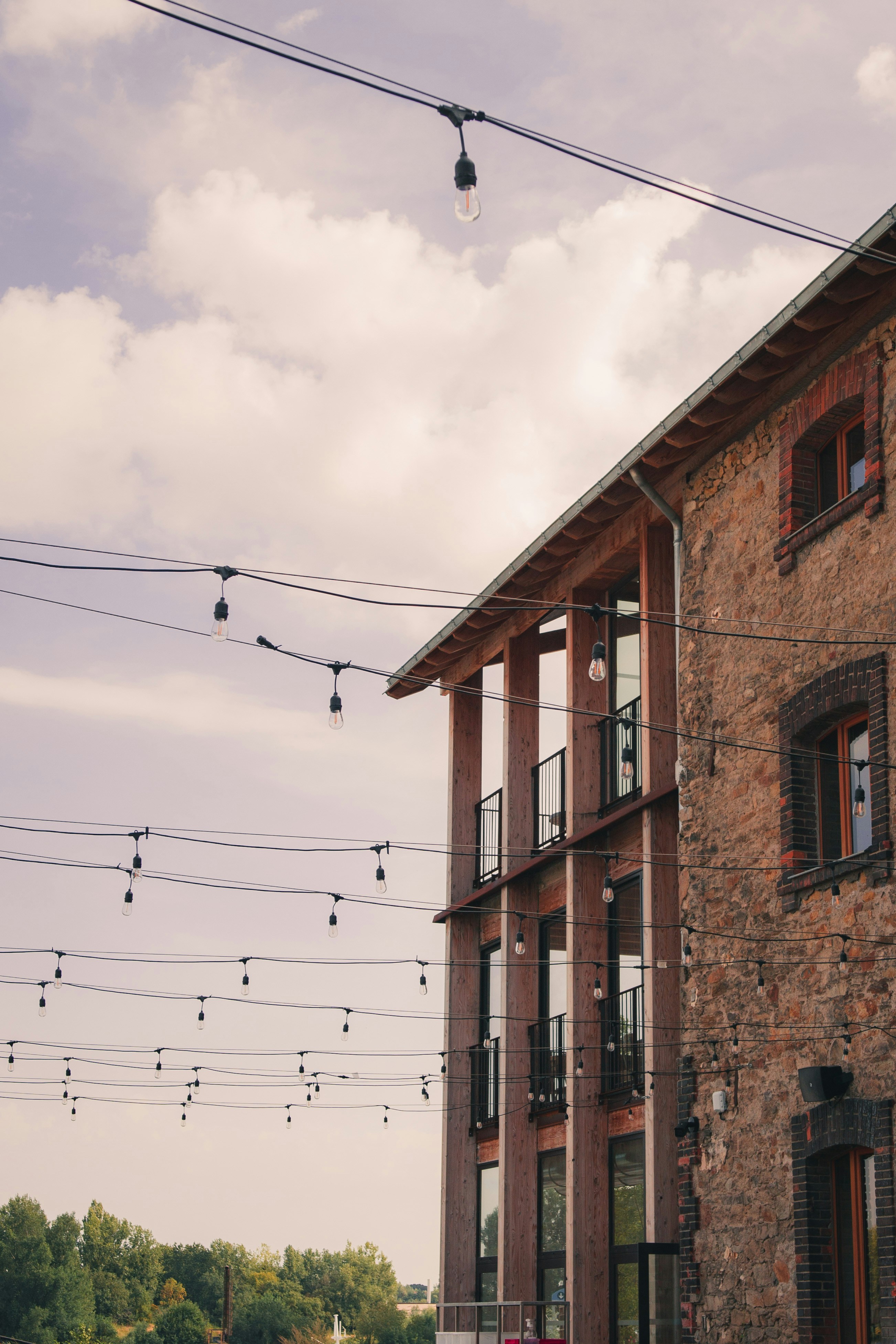 String lights over a brick atelier bathed in soft dusk