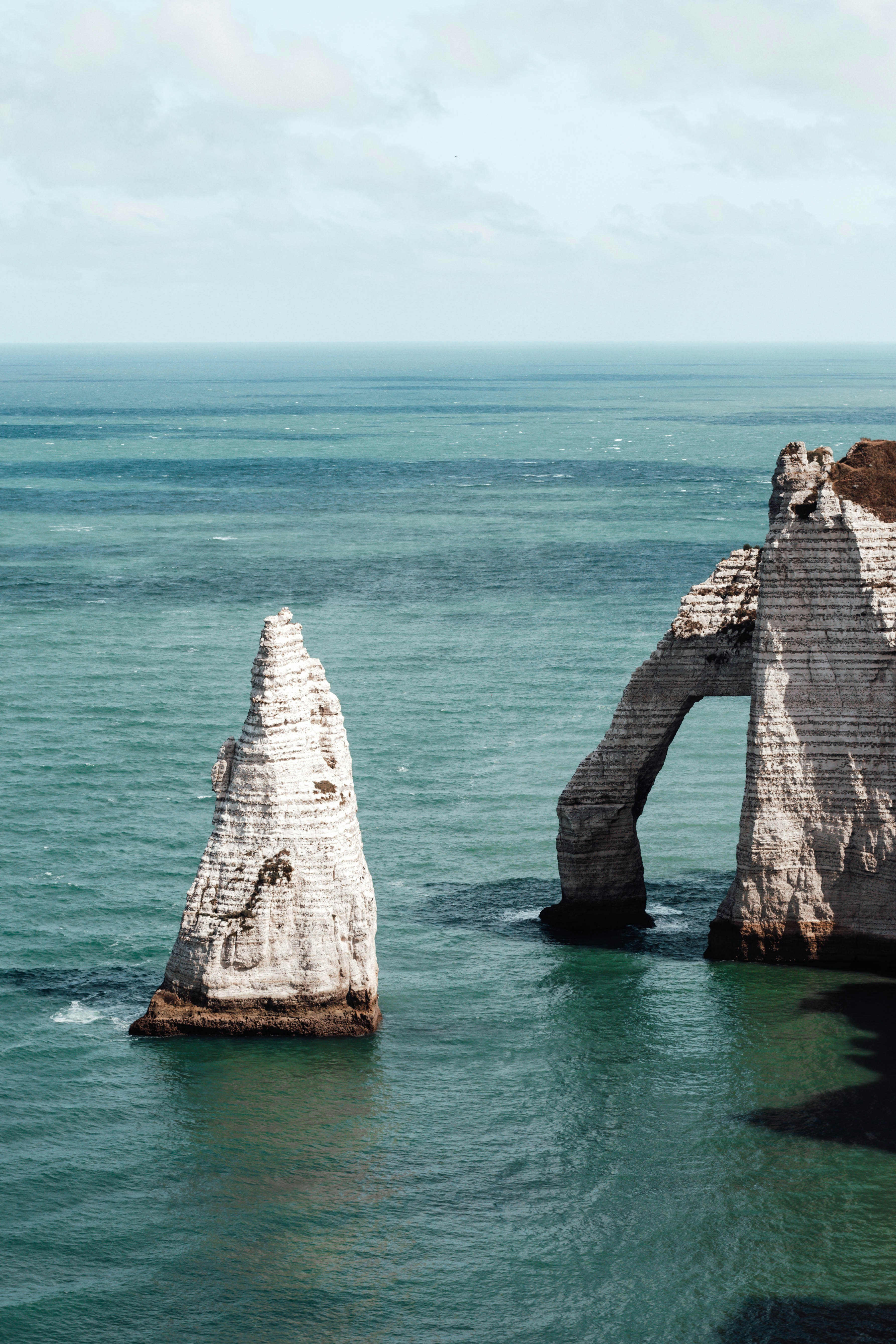 White and brown rock formation on blue sea during daytime photo – Free ...