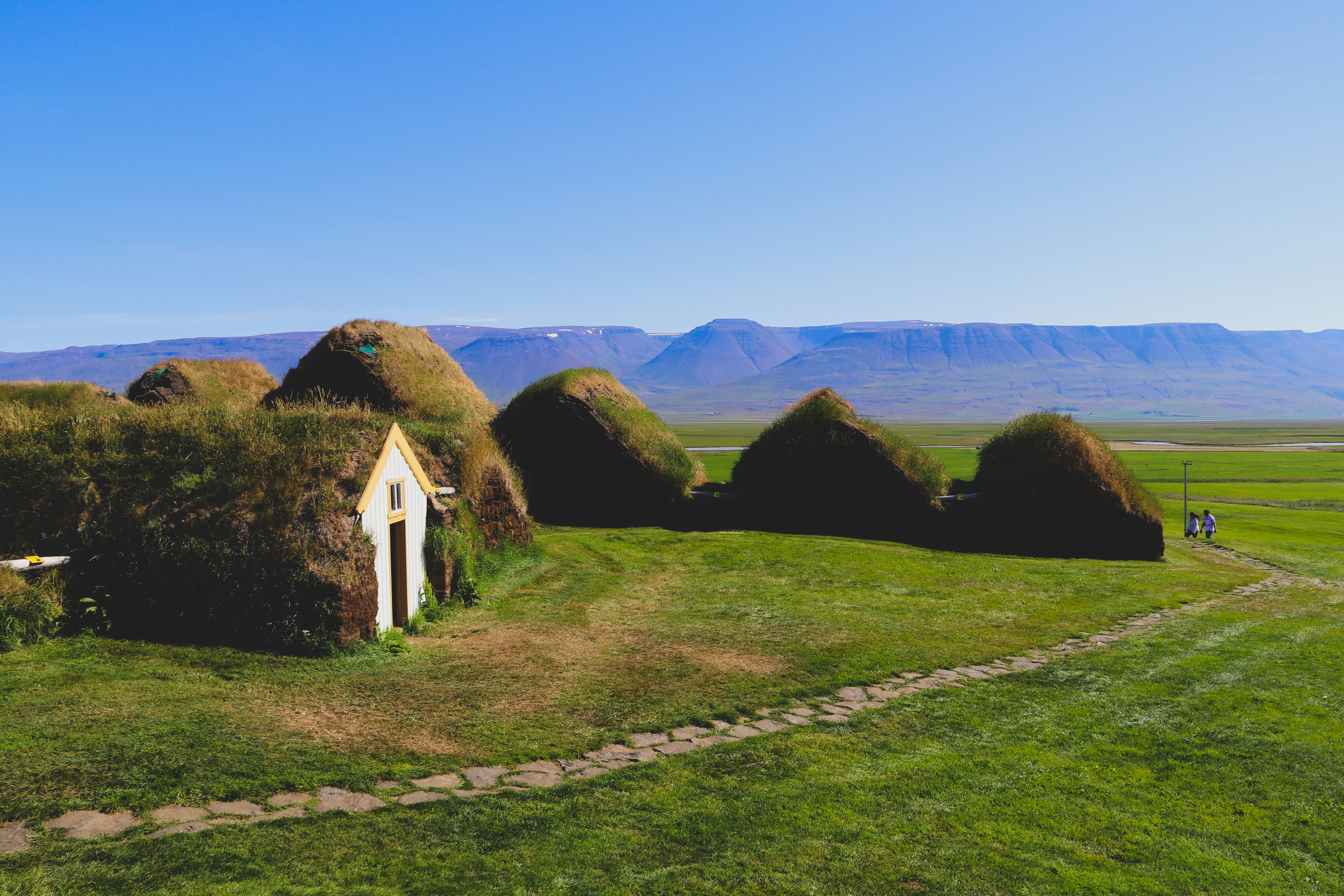 Sunlit Haystacks and a White Chapel on the Green Plain