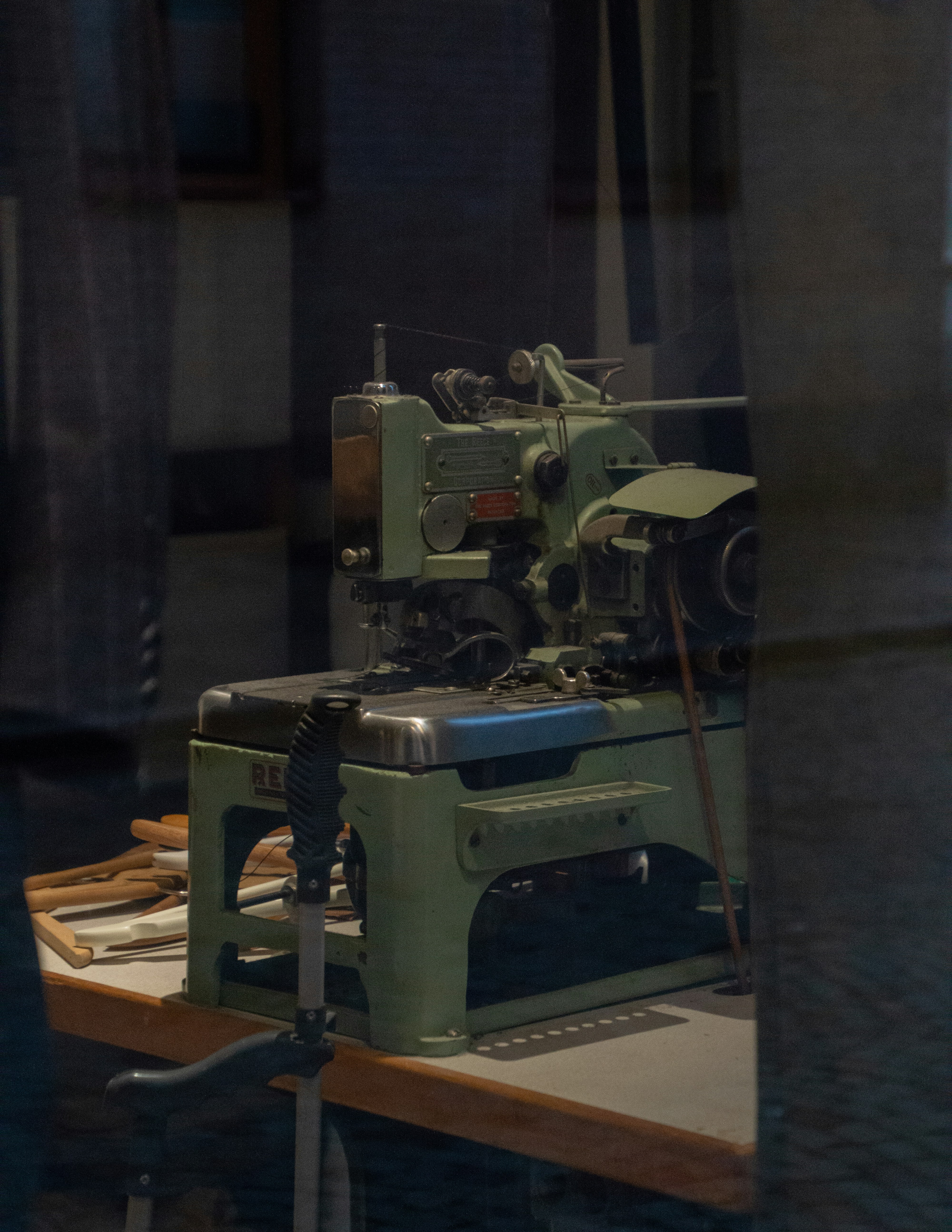 Green Relic Behind Glass: A Vintage Industrial Sewing Machine in Focus