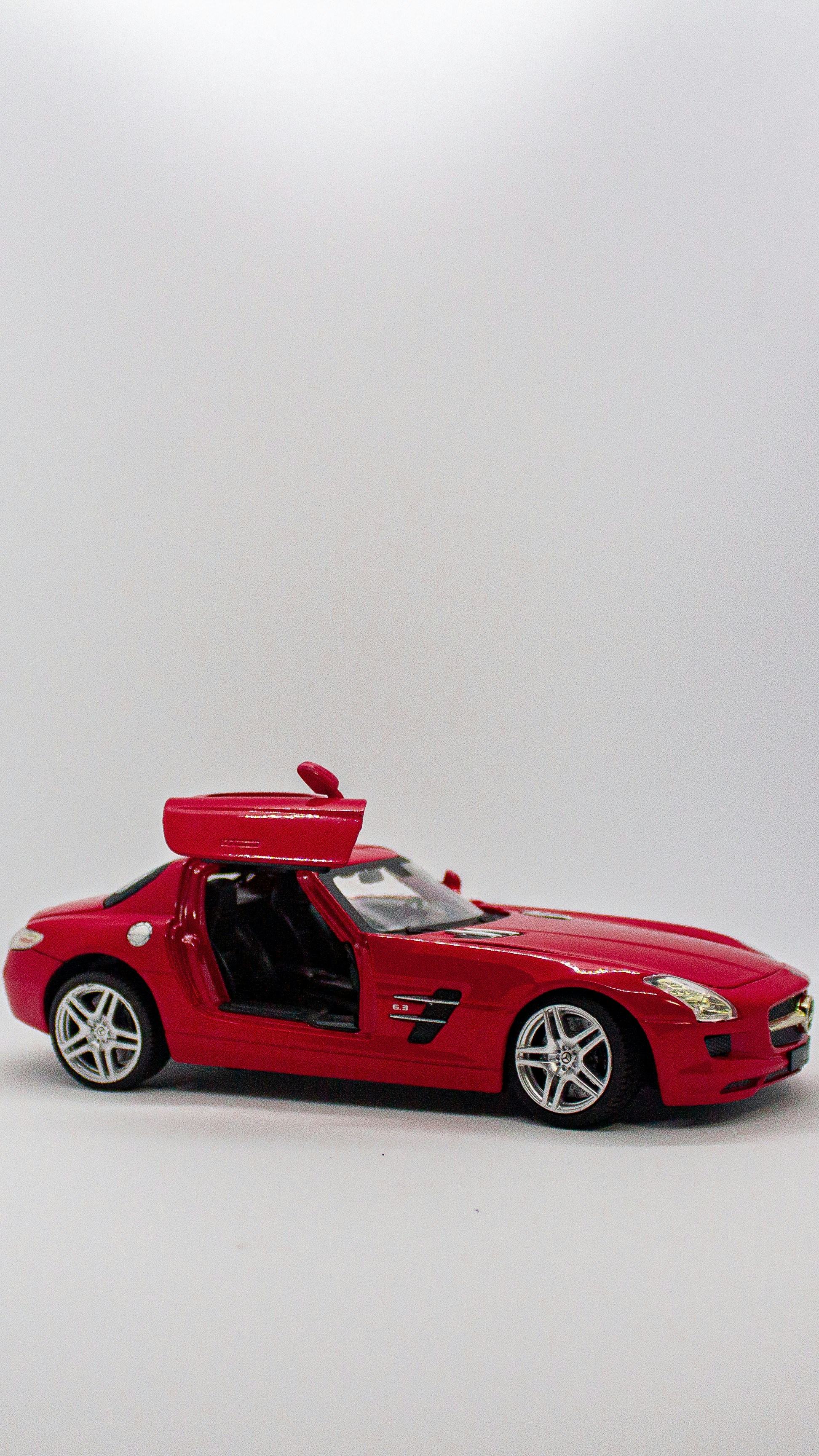 Red Gull-Wing Dream on White: A Studio Shot of a Toy Sports Car