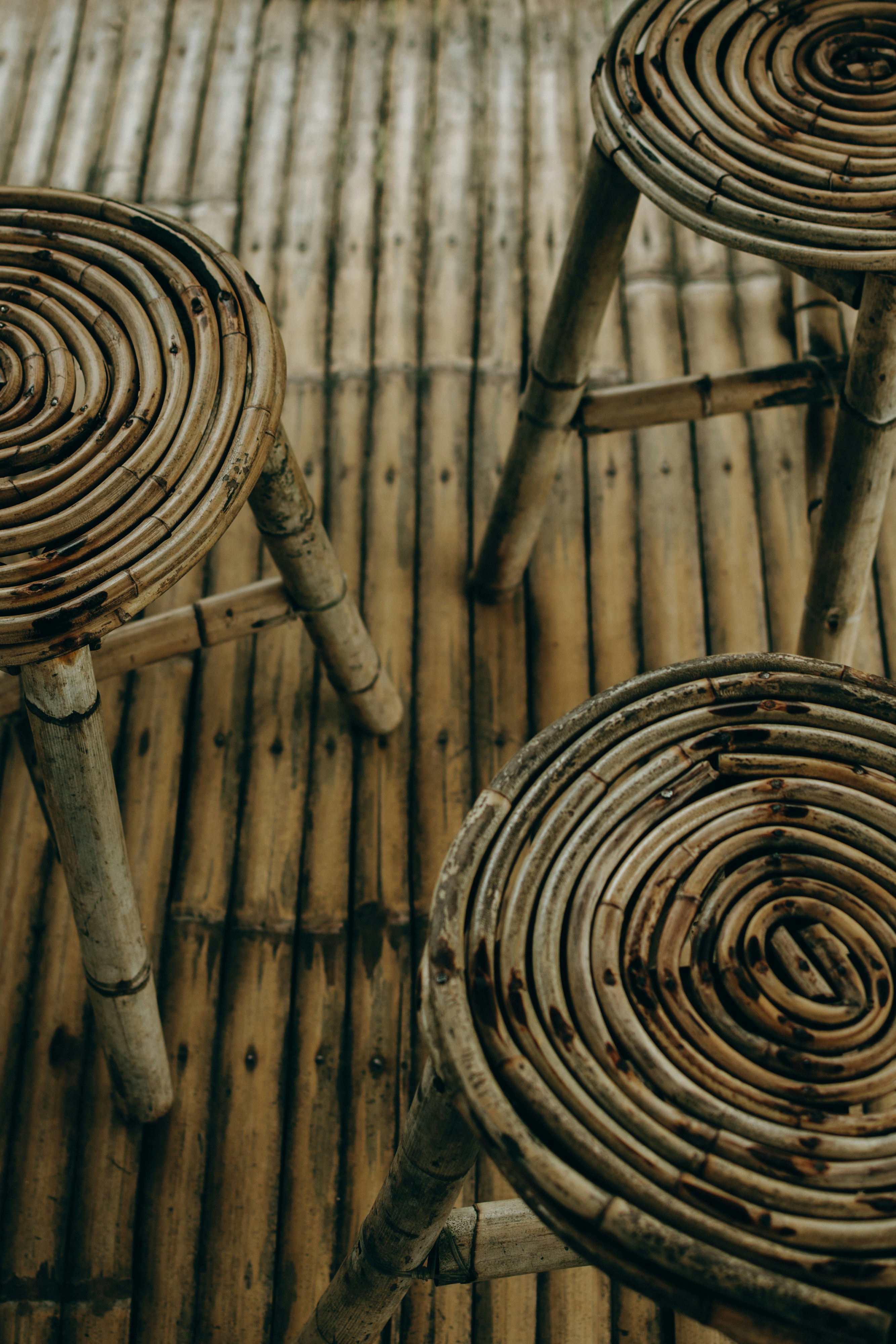 Rust and Rattan: A Top-Down Study of Circular Stools on Worn Wood