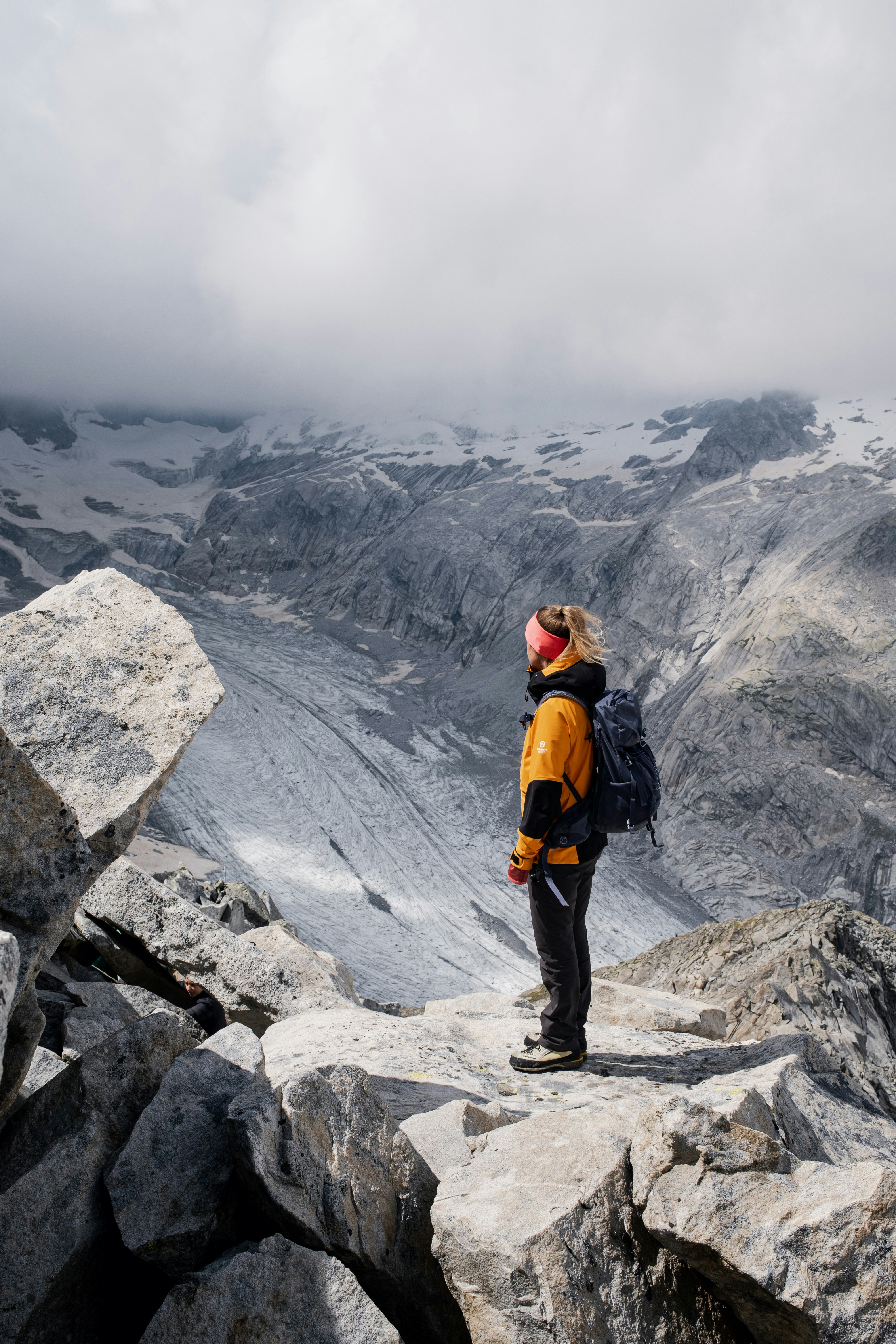 Climber on the Edge: A lone hiker surveys a snow-dusted abyss