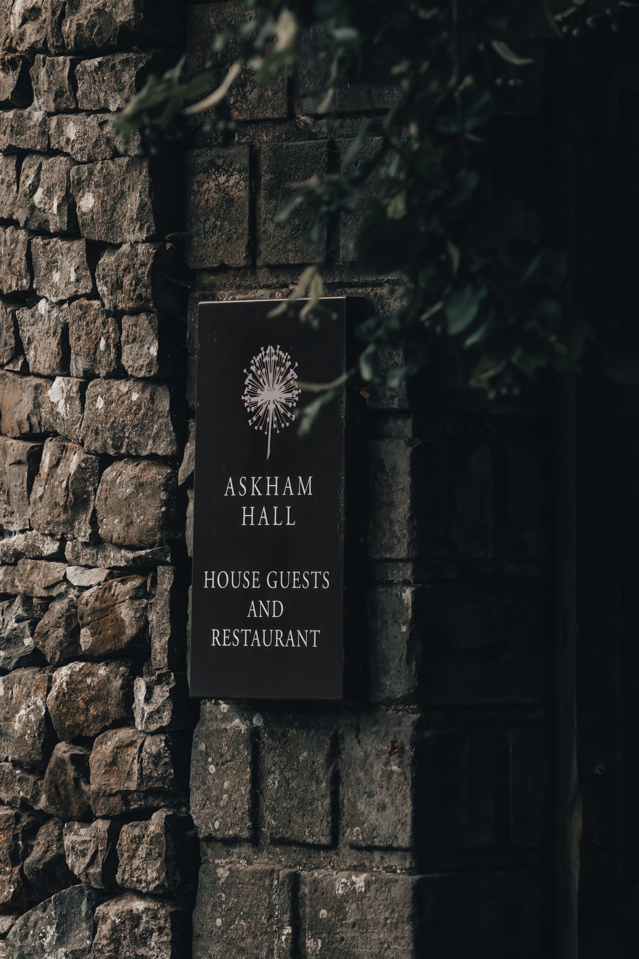 Askham Hall plaque on rugged wall at dusk