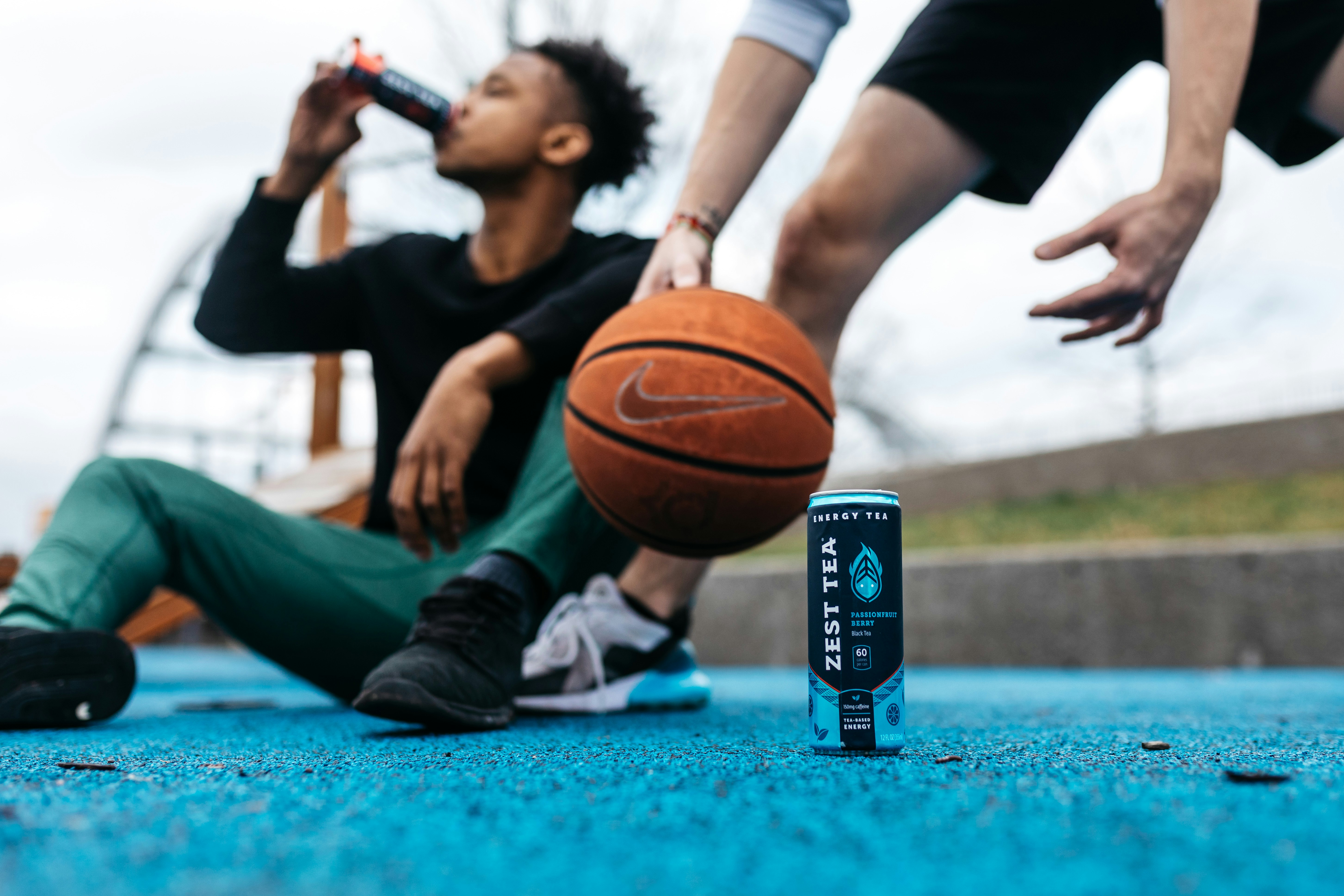 Low-Angle Moment: Dribble Pause Amid Teal Court and Energetic Feet